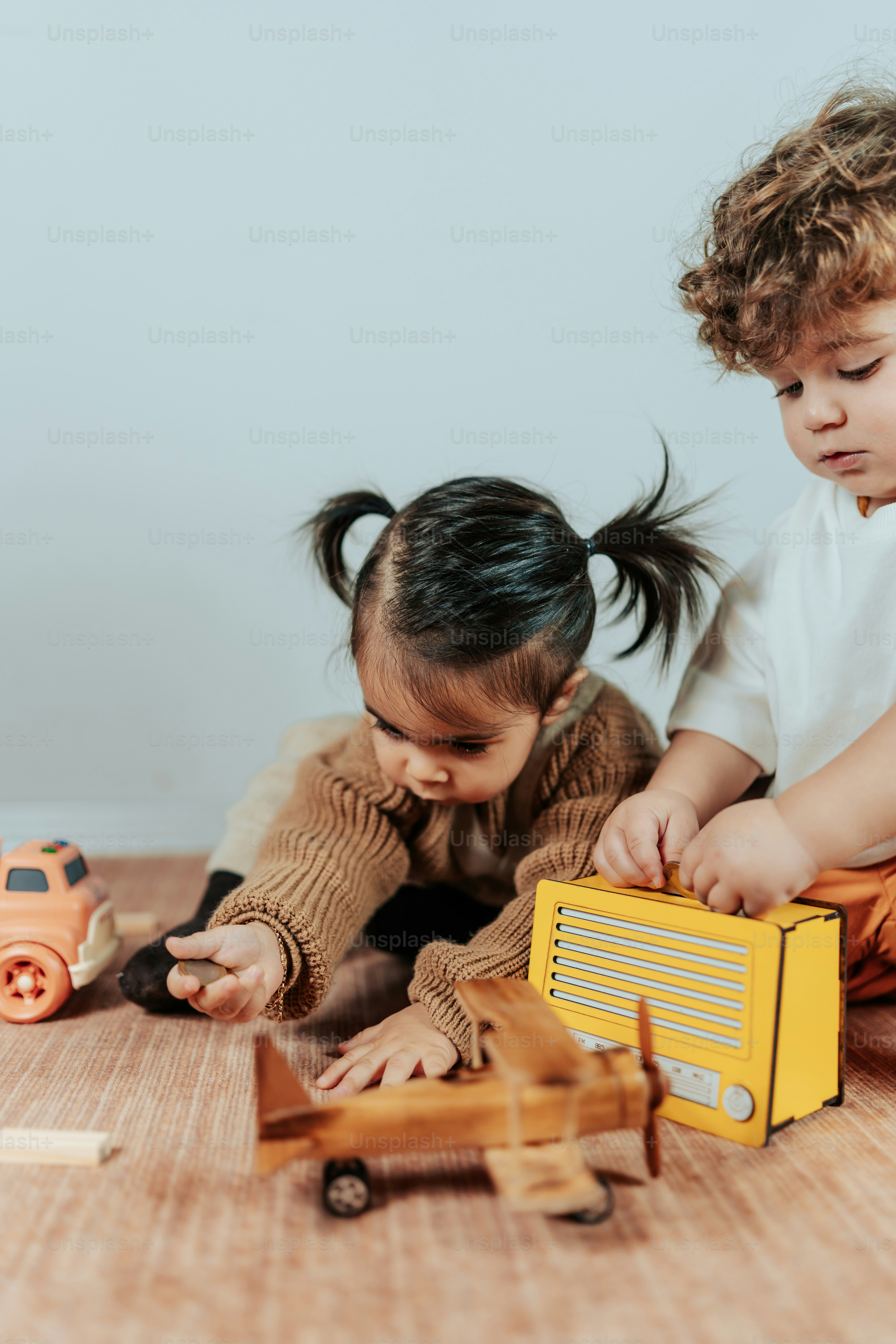 Two children playing with toys on the floor photo – Children playing ...
