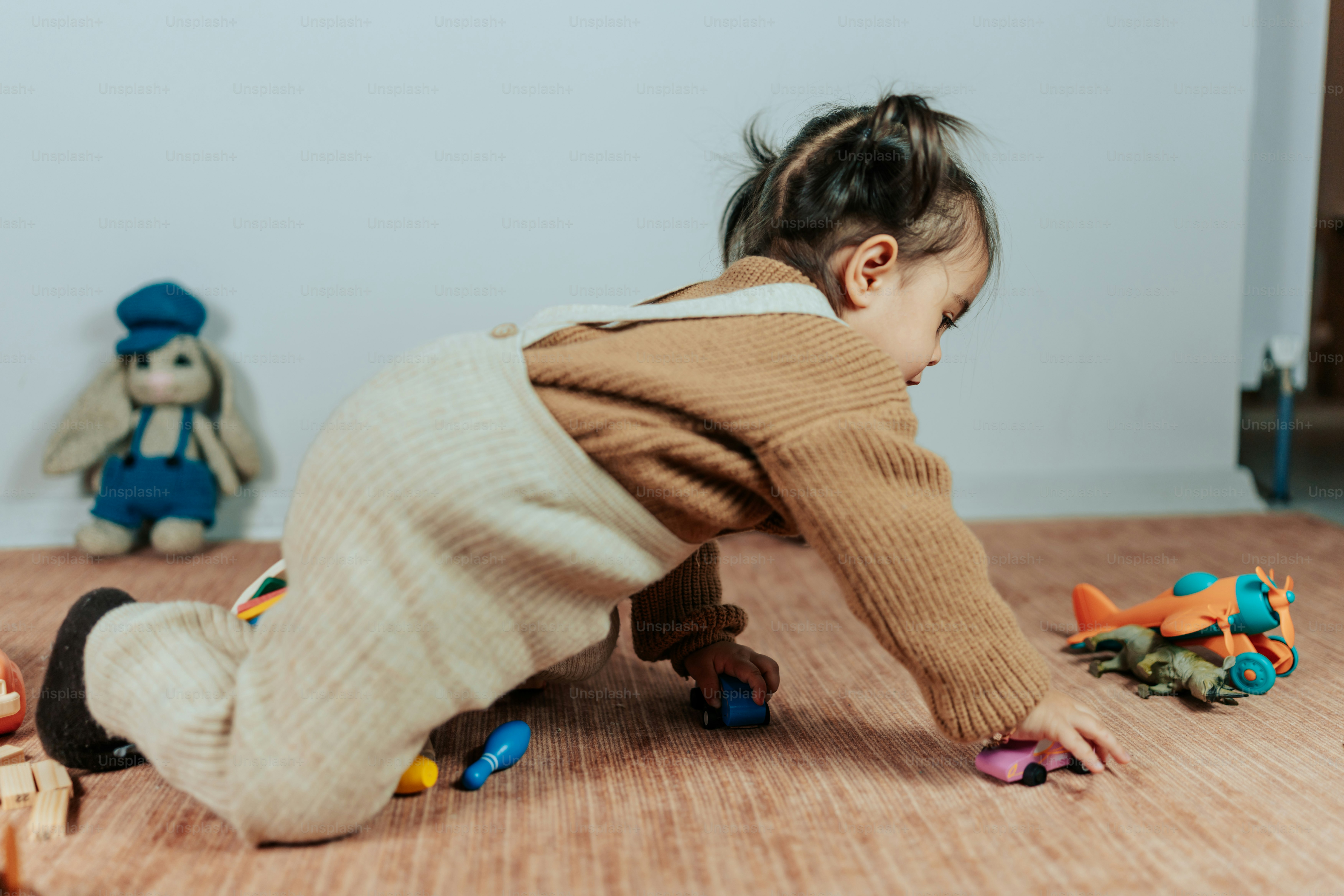 A baby crawling on the floor playing with toys photo – Children playing ...