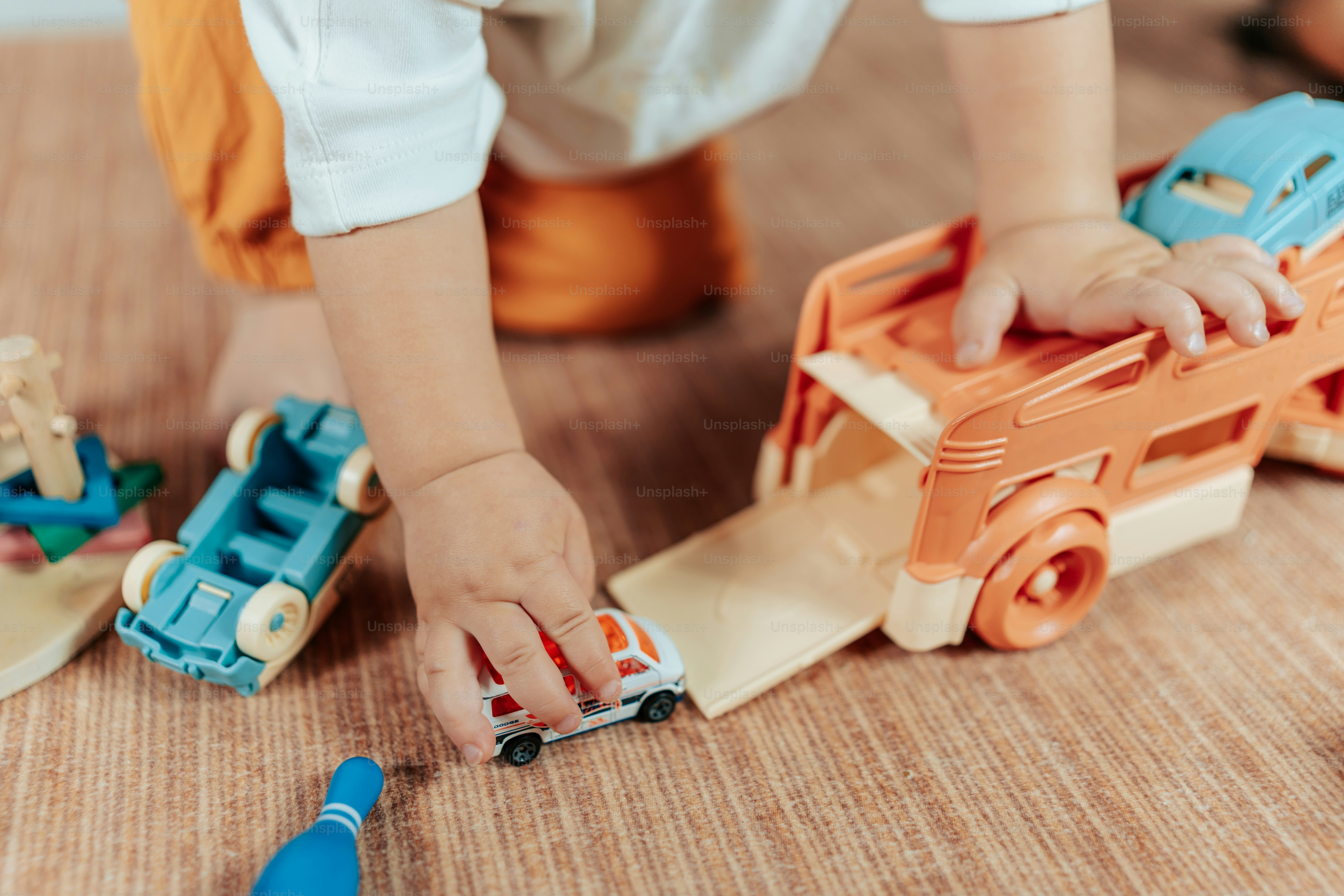A child playing with wooden toys on the floor photo – Wooden toys Image ...