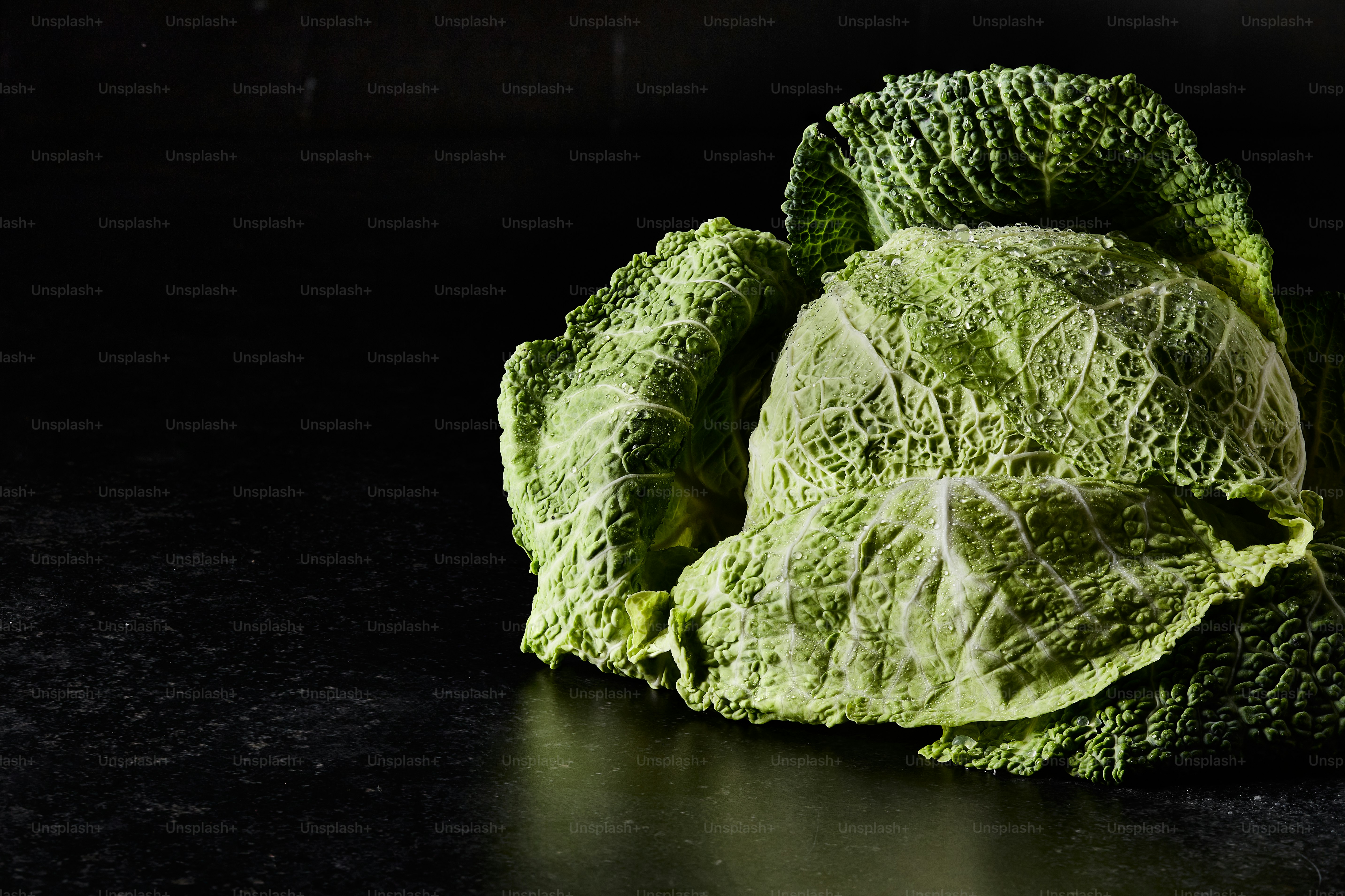 A pile of green cabbage sitting on top of a table photo – Savoy cabbage ...