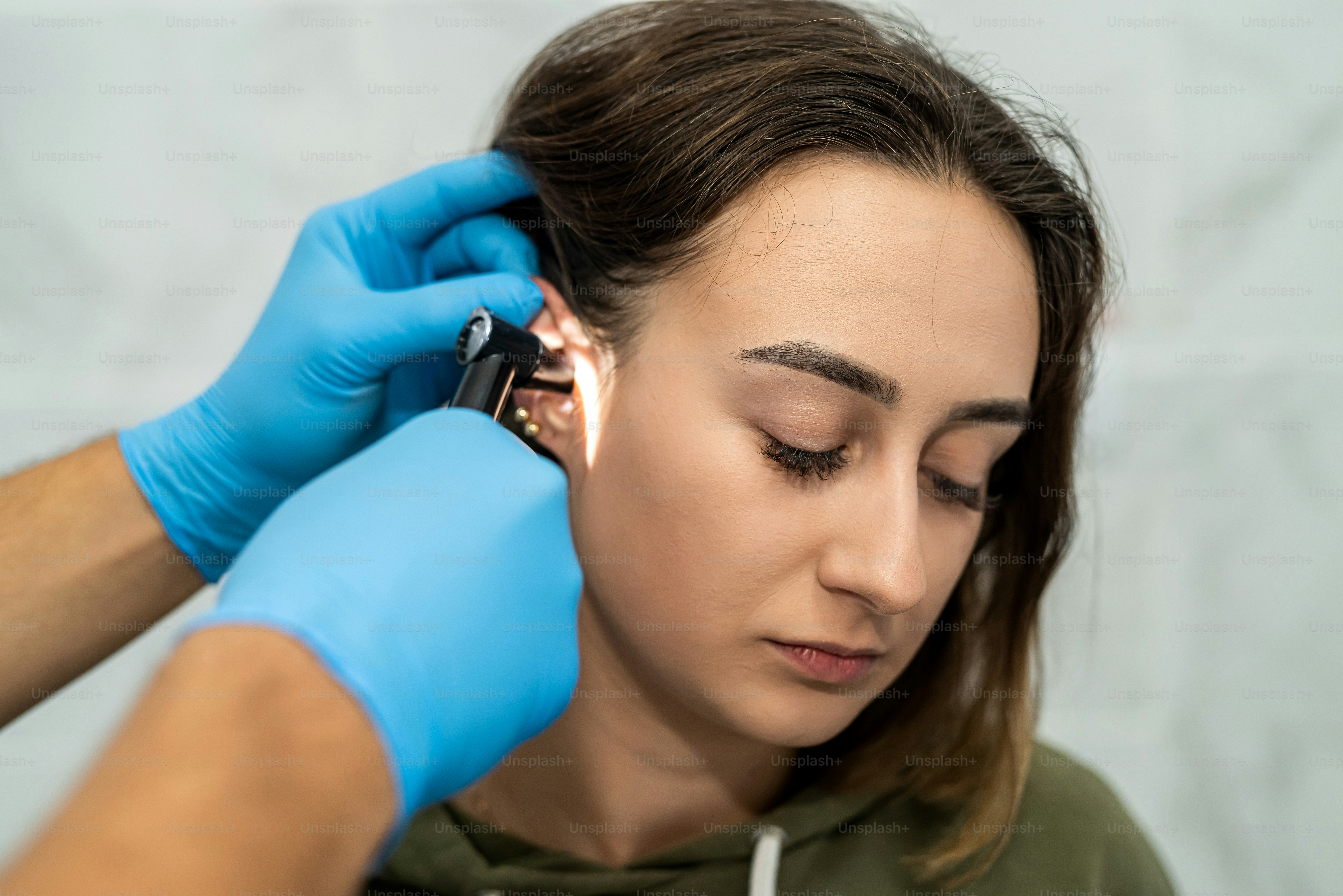 Un médecin ORL examine l’oreille à l’aide d’un otoscope d’une patiente ...