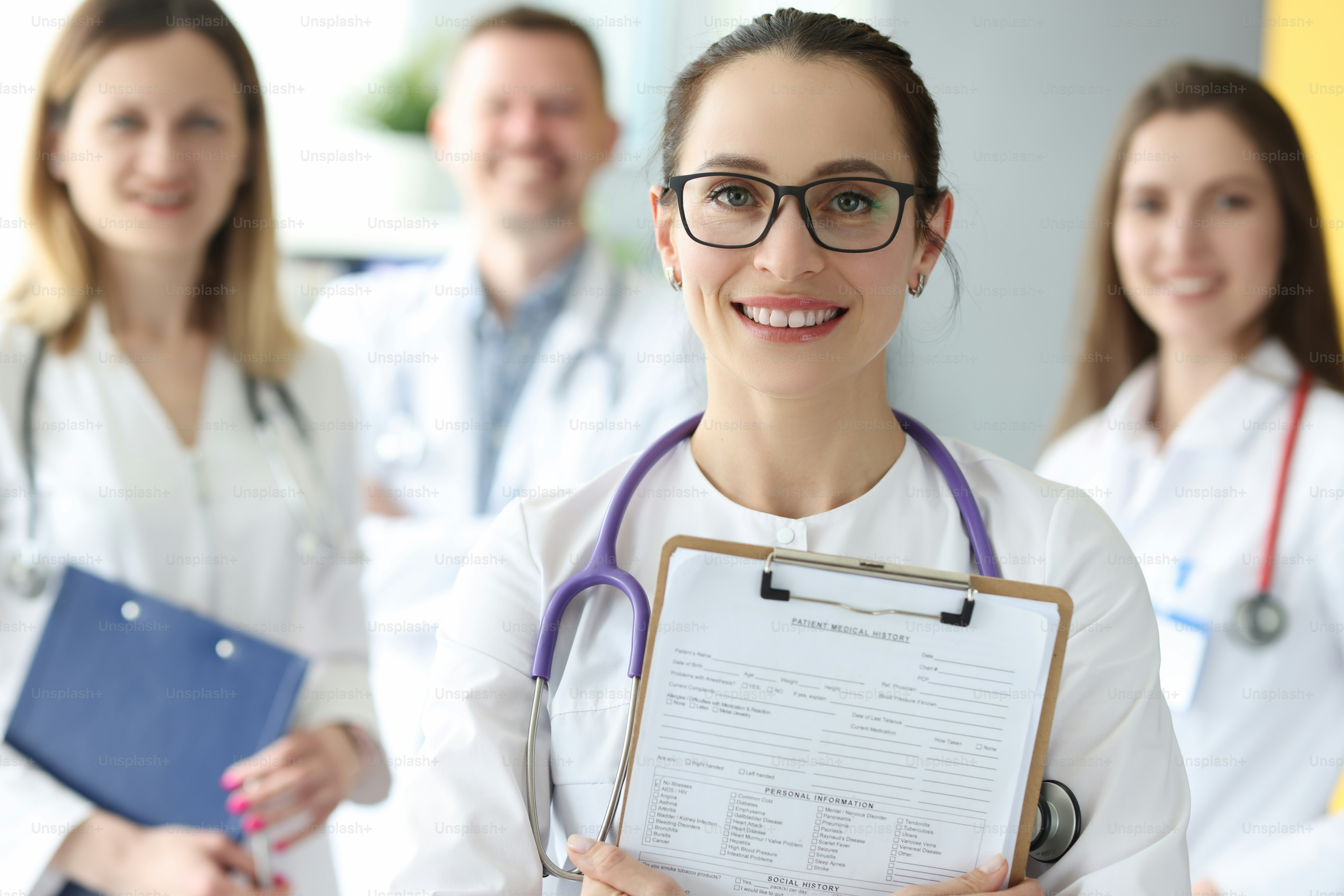 Portrait of female doctor in glasses with patient medical history in ...