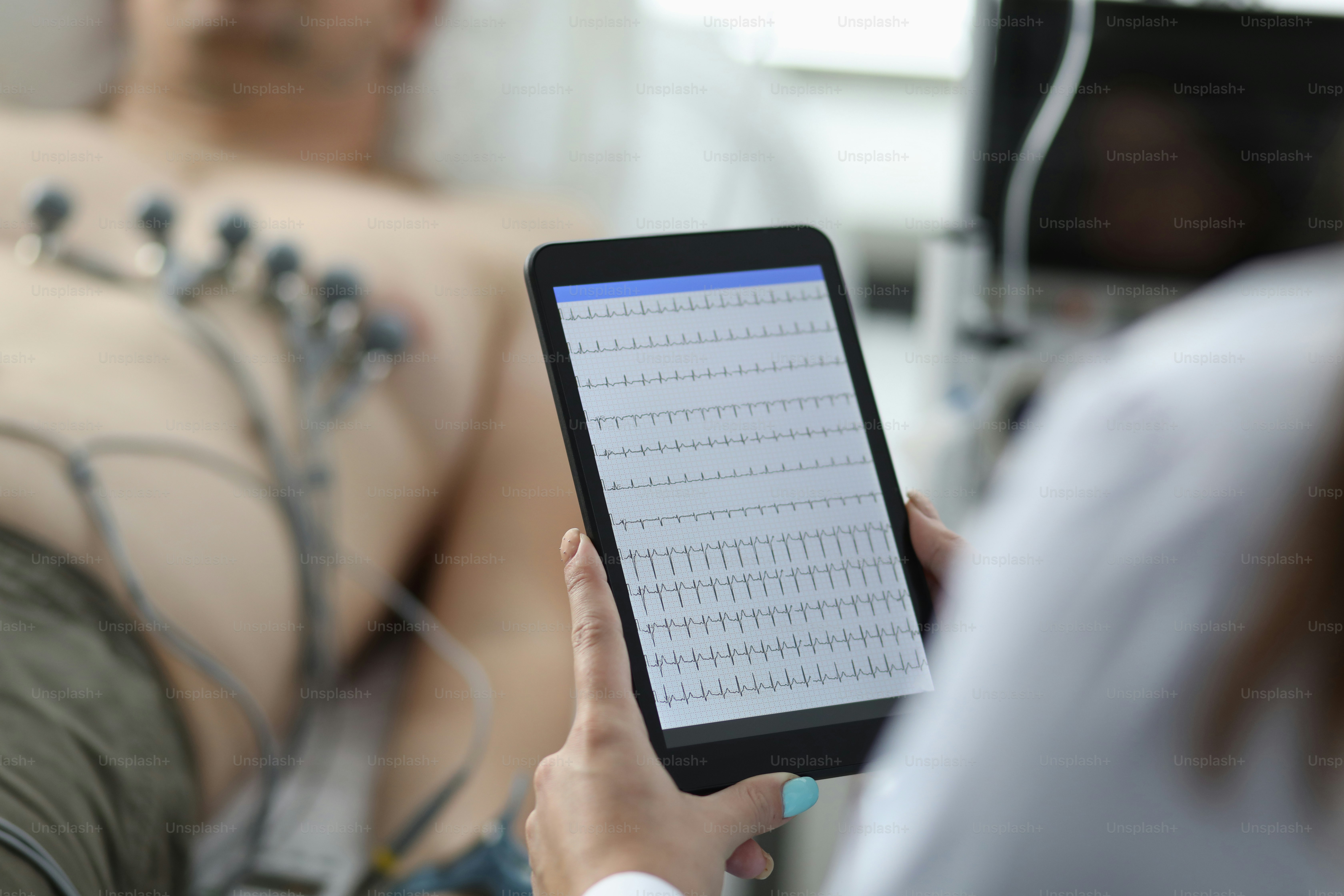 Close-up of female cardiologist holding tablet and examine patients ...