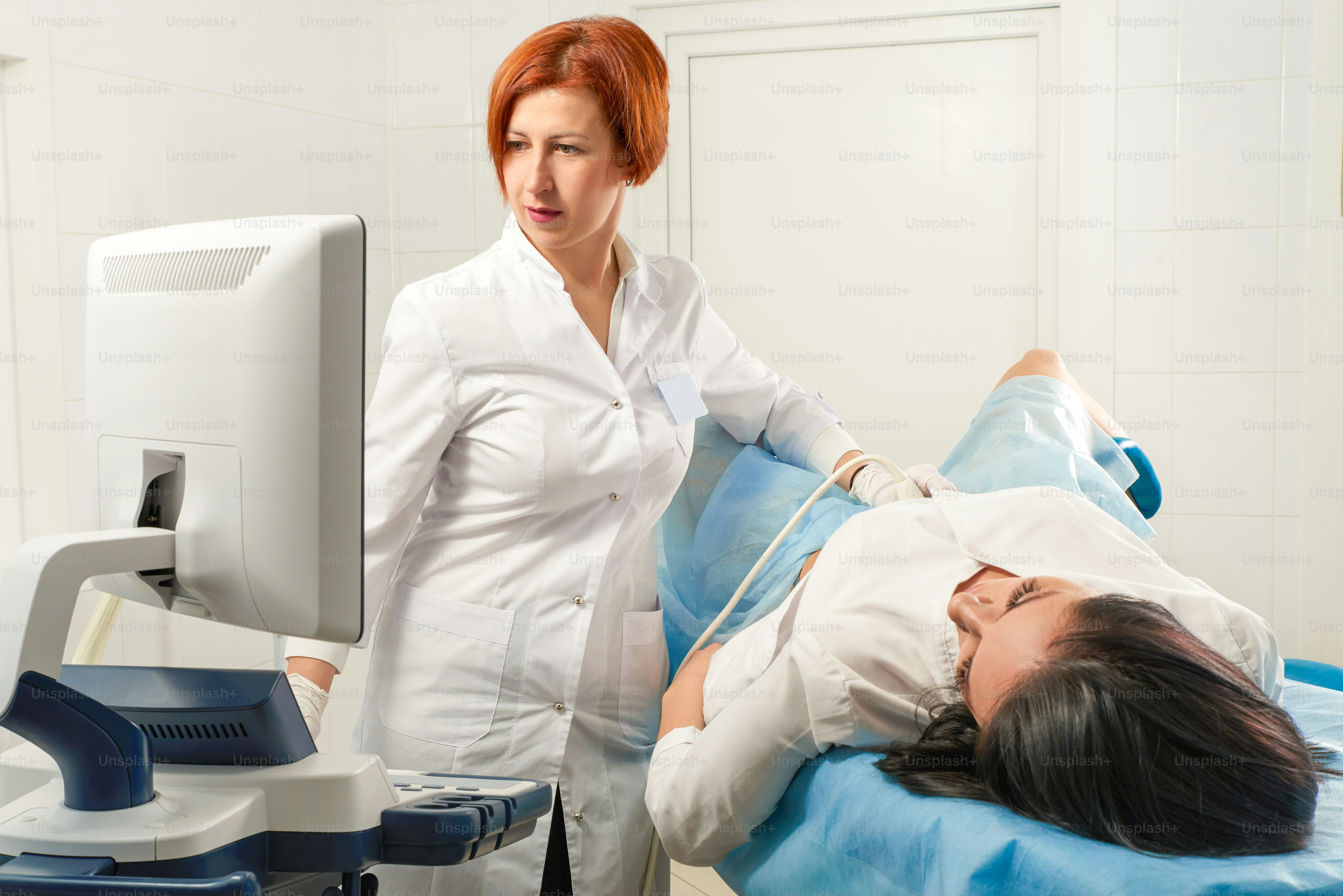 Gynecologist doing ultrasound scanning with Diagnostic equipment for a ...
