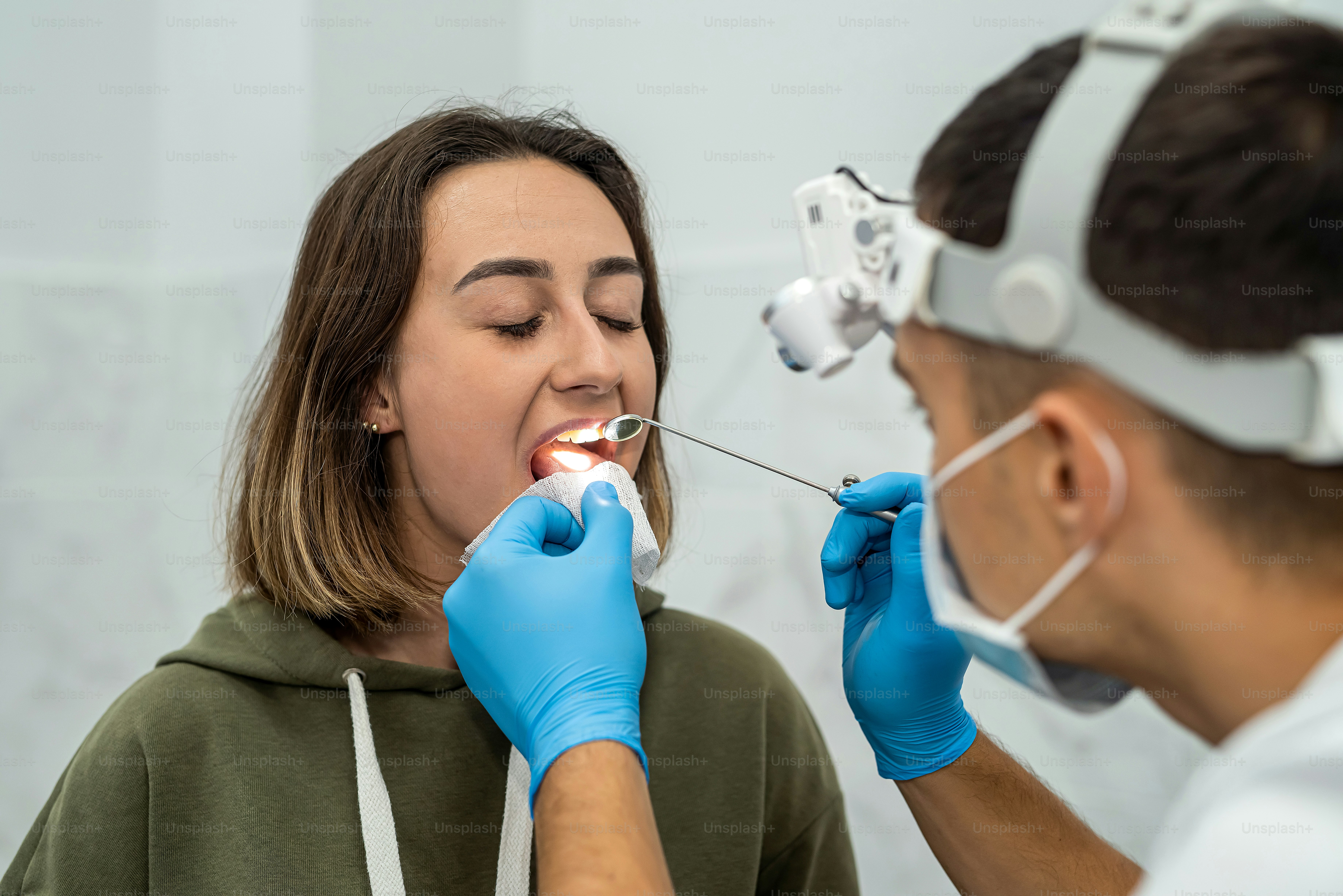 Doctor using an inspection spatula to examine a patient's throat. An ...