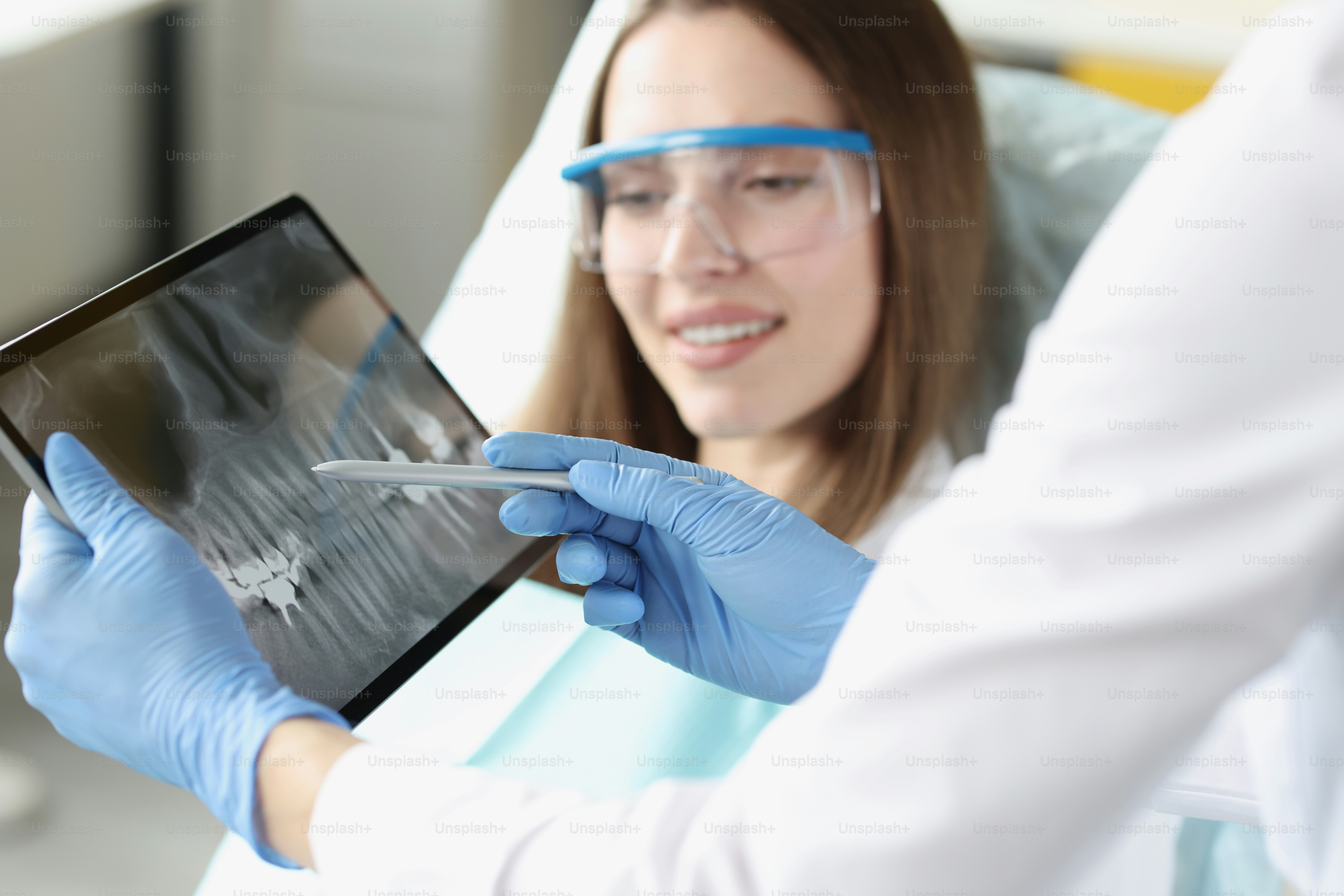 Portrait of patient on consultation in clinic, doctor describe teeth x ...