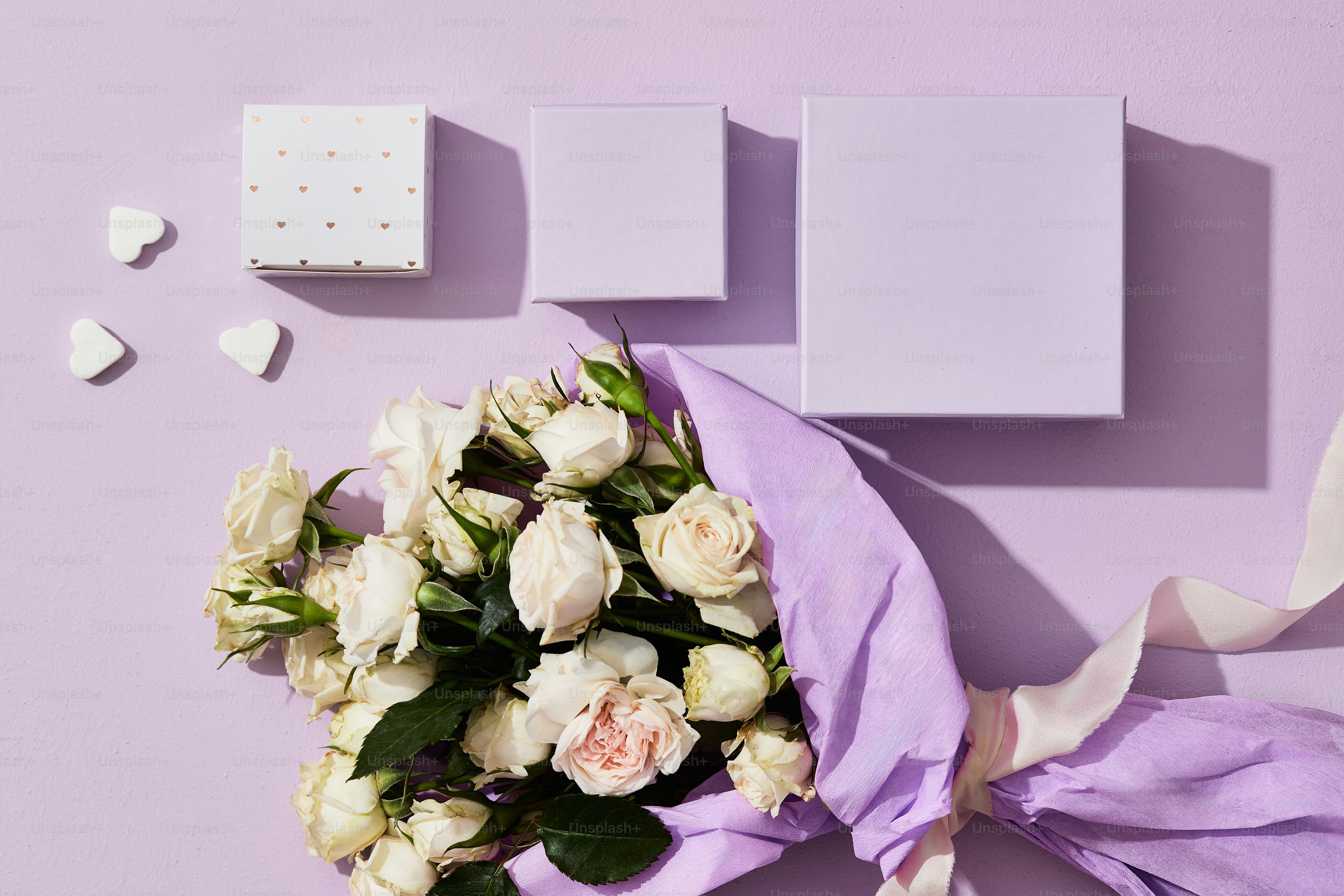A bouquet of white roses sitting on top of a purple table photo – Roses ...