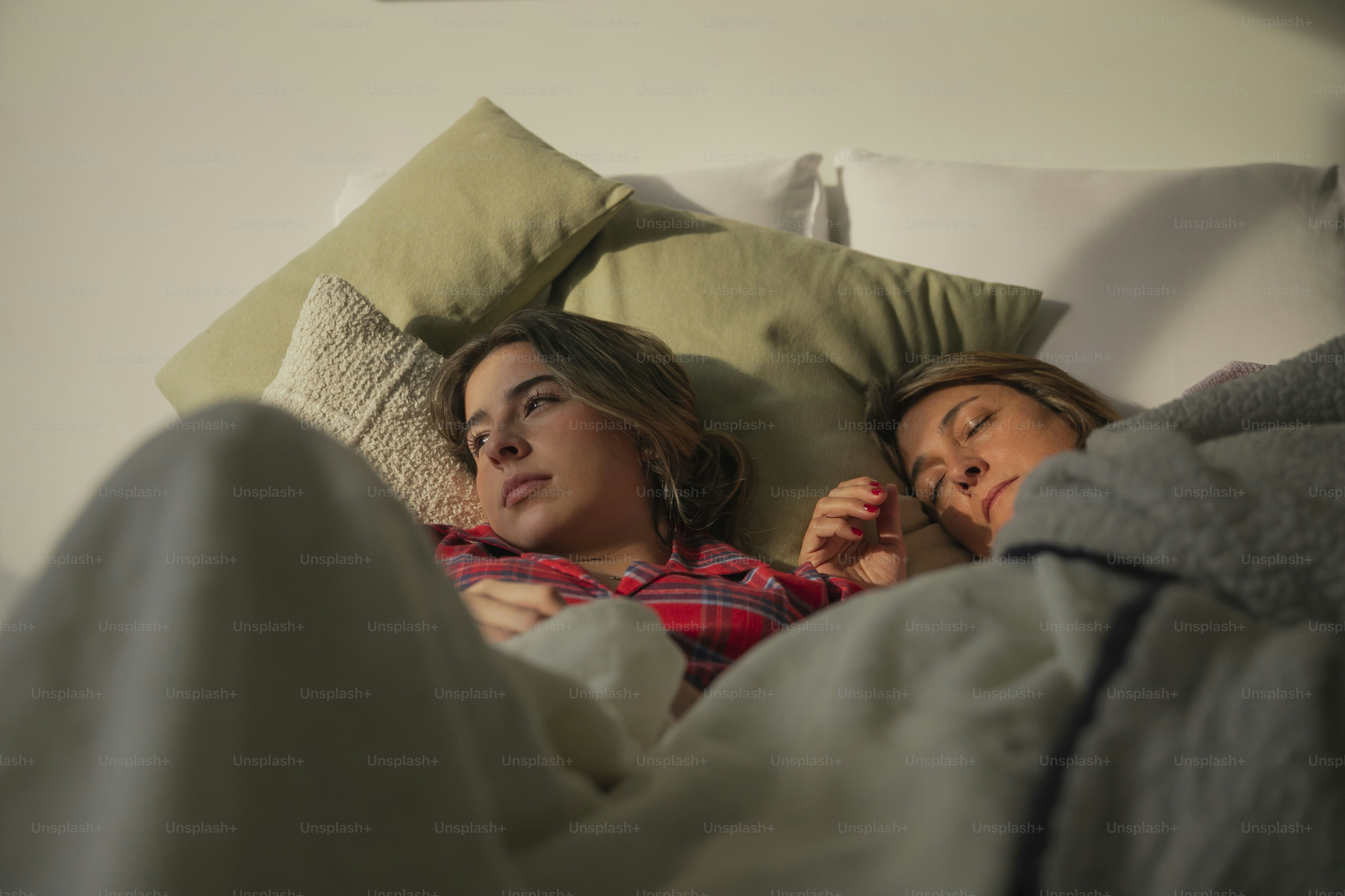 A couple of women laying in bed next to each other photo – Relaxing ...
