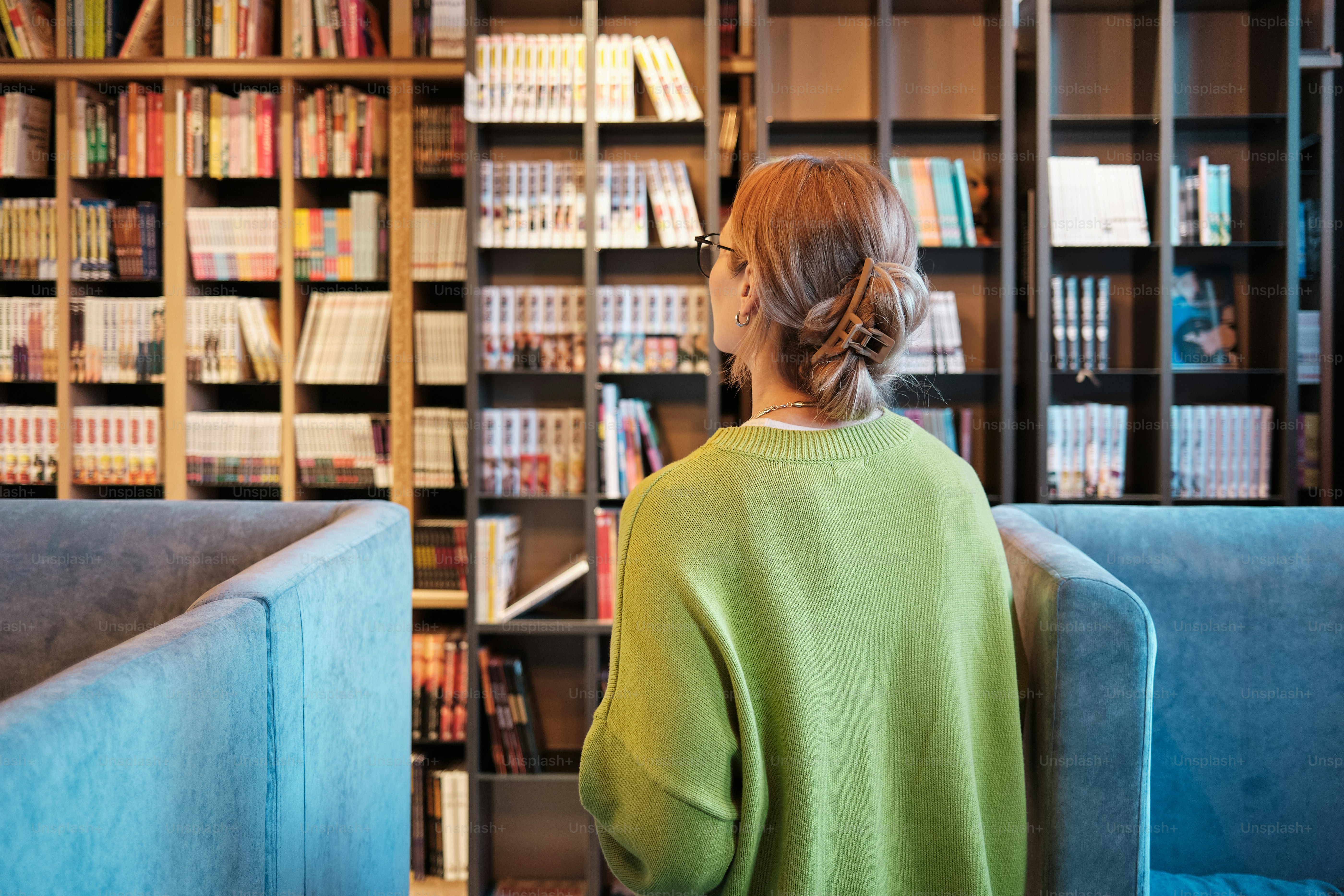 Woman in green sweater looking at bookshelves photo – Books Image on ...