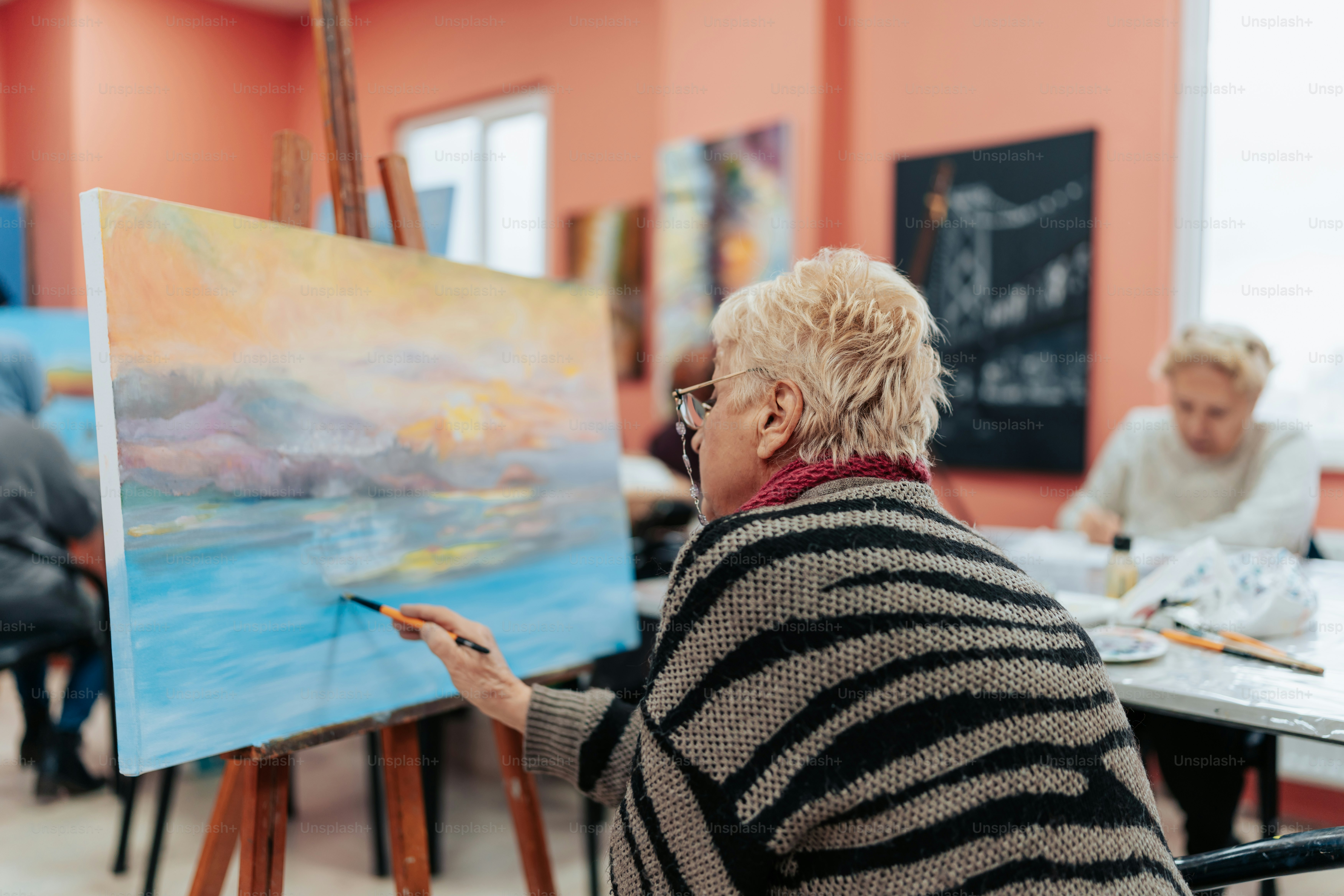 A woman is painting in an art class photo – Workshop Image on Unsplash