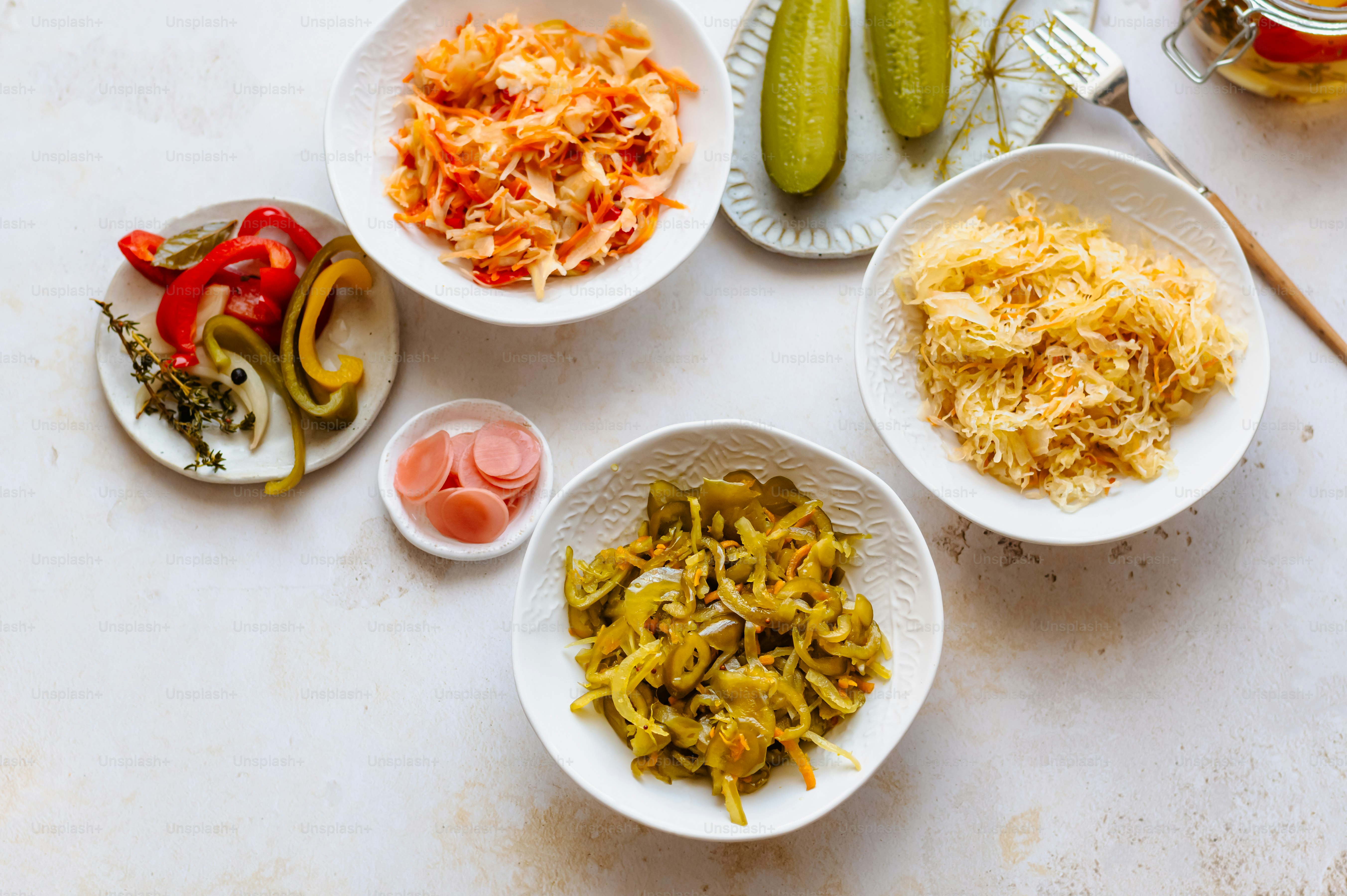 A table topped with bowls of food and pickles photo – Pickles Image on ...