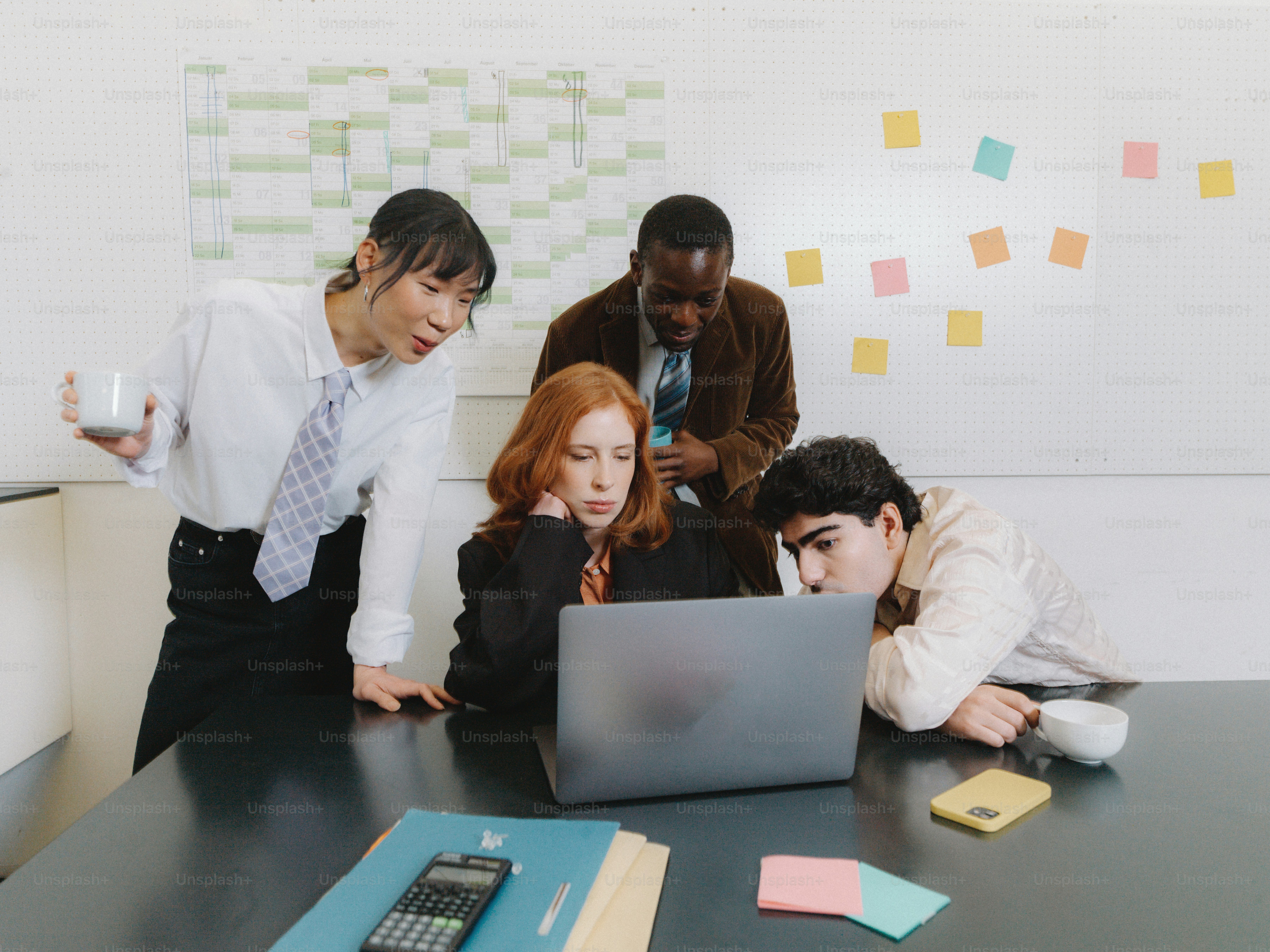 A group of people standing around a laptop computer photo – Meeting ...