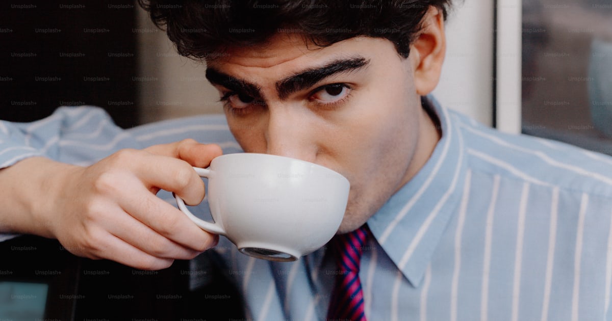 셔츠와 넥타이를 맨 남자가 컵을 마시고 있다 사진 Unsplash의 컵 이미지