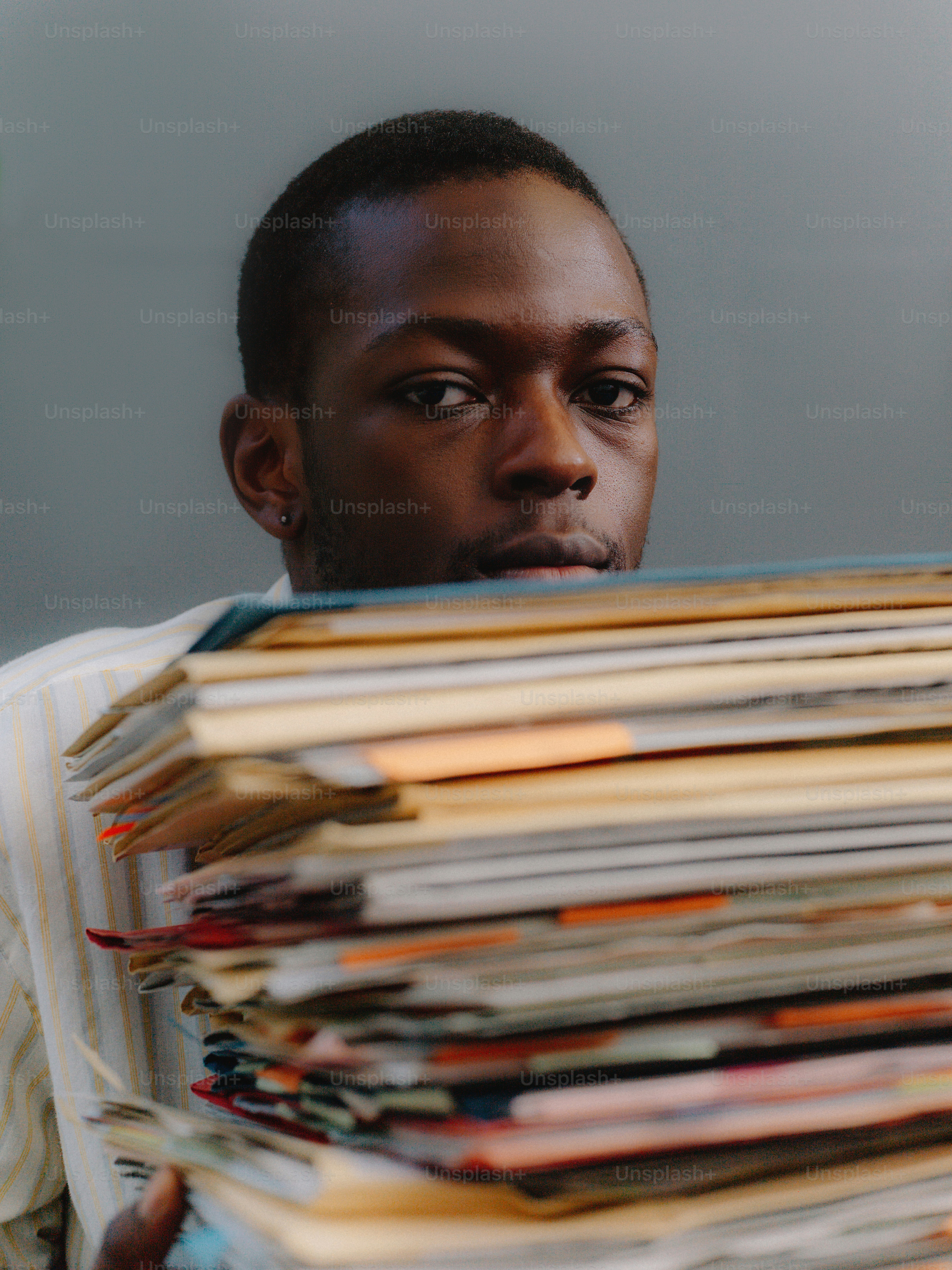 A man holding a stack of papers in front of his face photo – Files ...