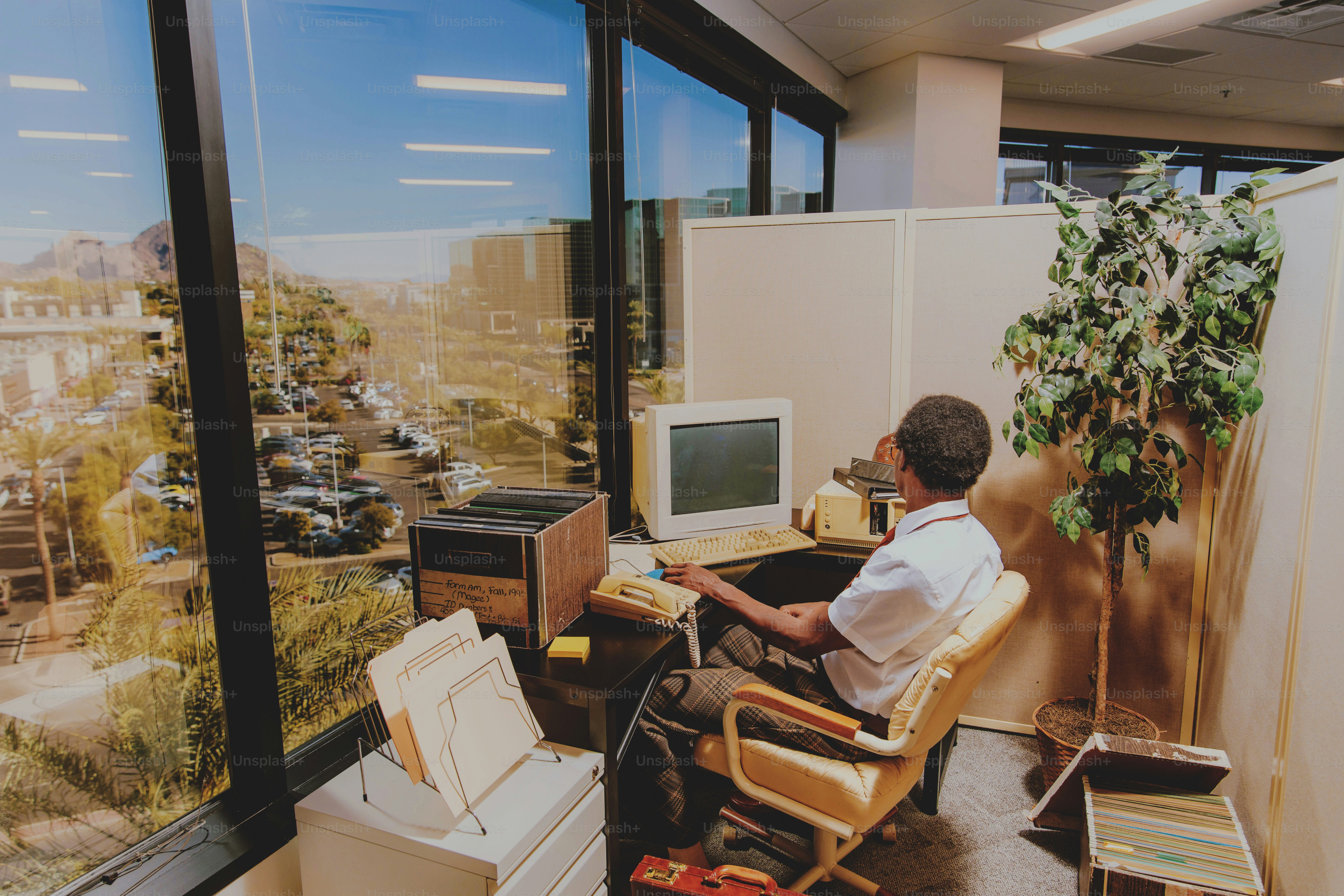 A man sitting at a desk working on a computer photo – Team Image on ...