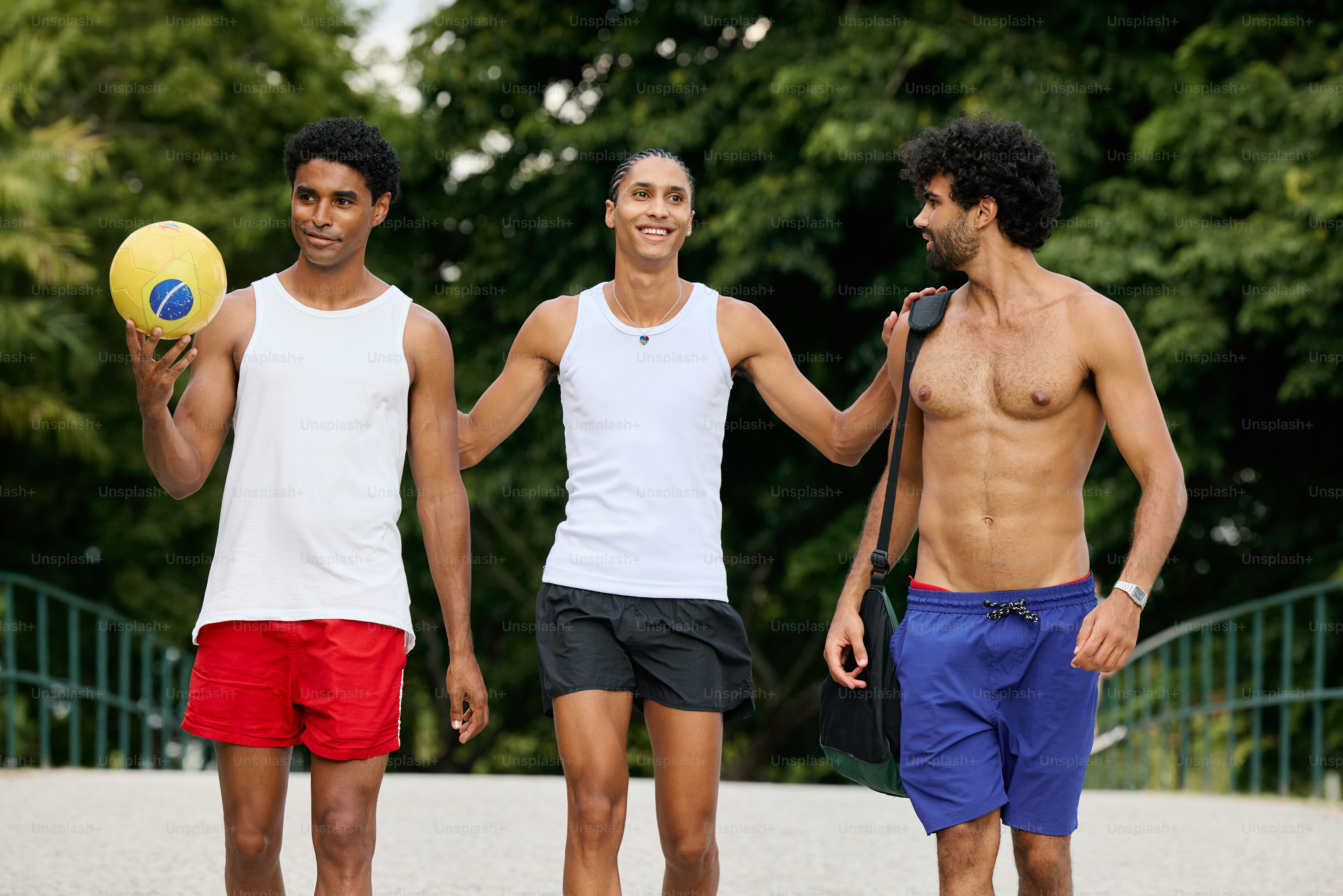 A group of three men standing next to each other photo – Models Image ...