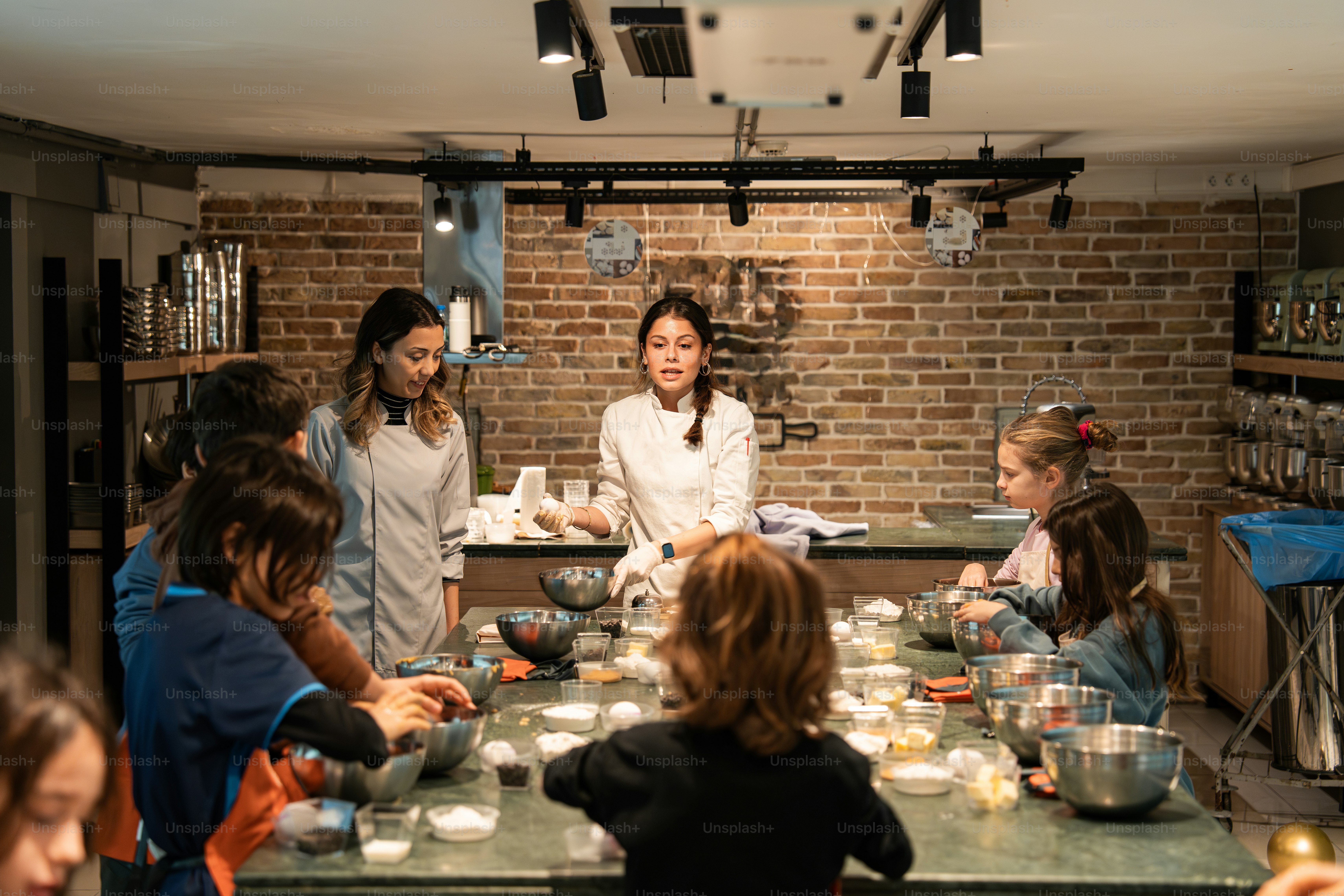 A group of people standing around a kitchen counter photo – Workshop ...