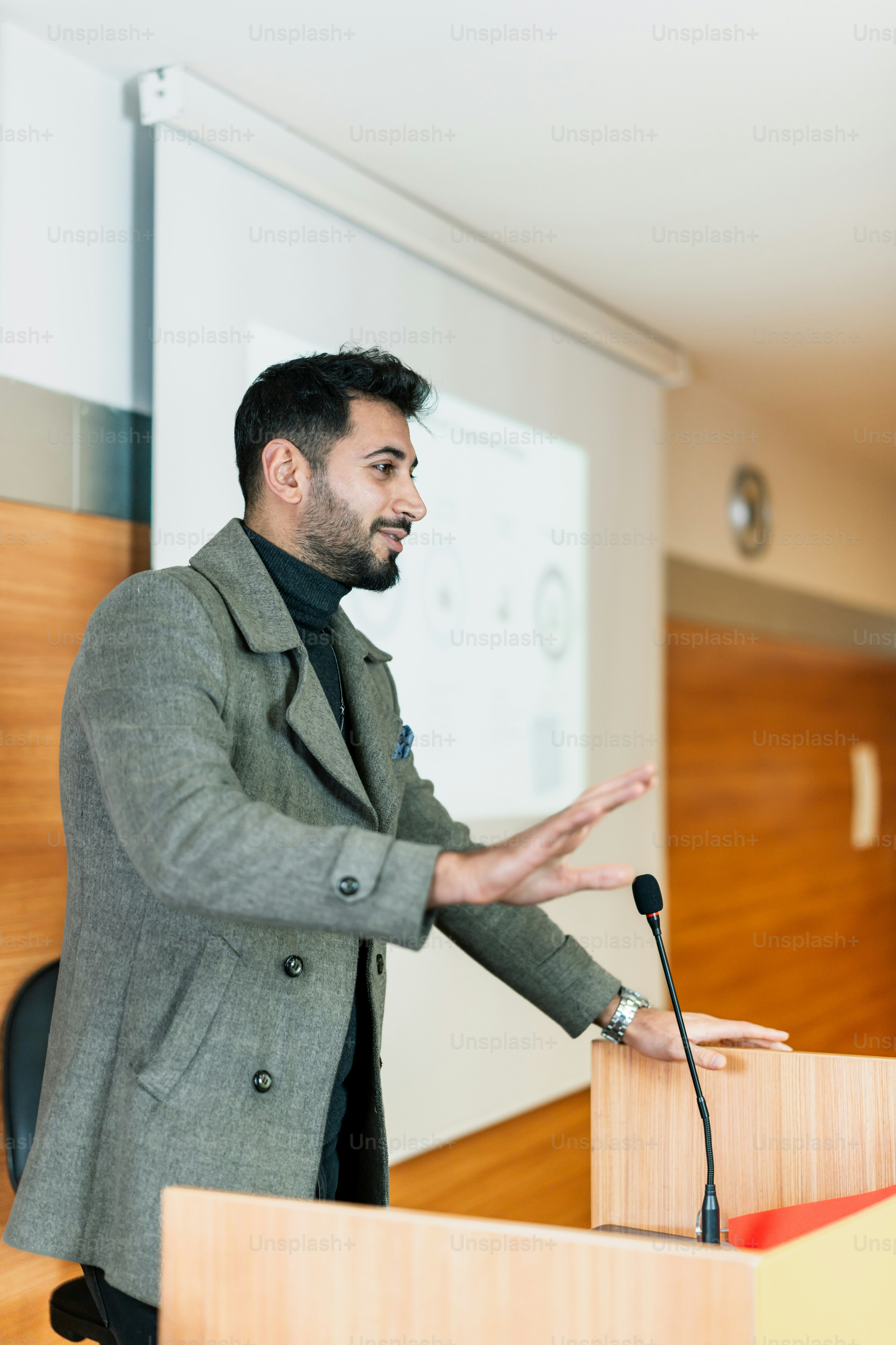 A man standing at a podium giving a speech photo – Public speaking ...
