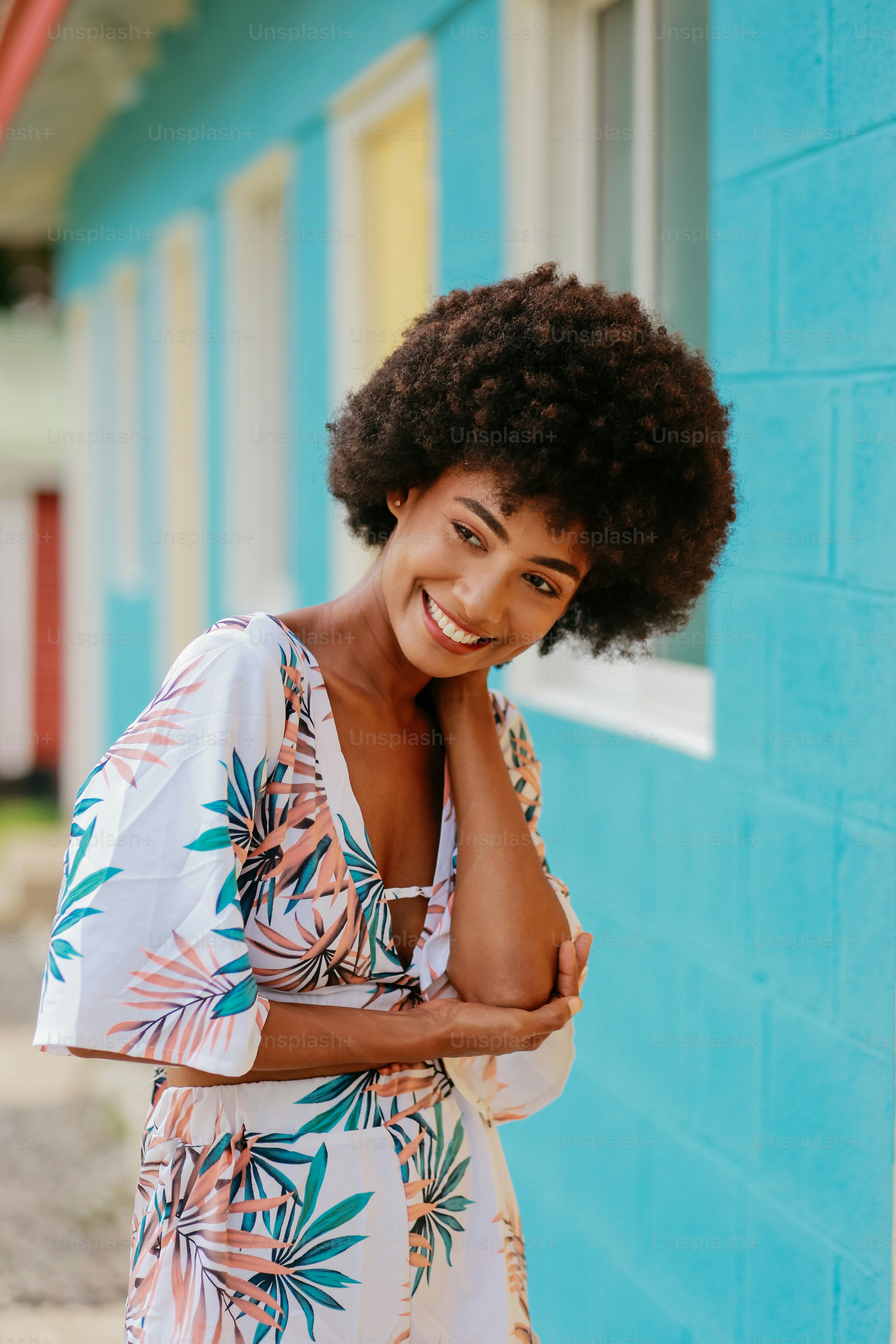 A woman standing in front of a blue building photo – Happy emotions ...