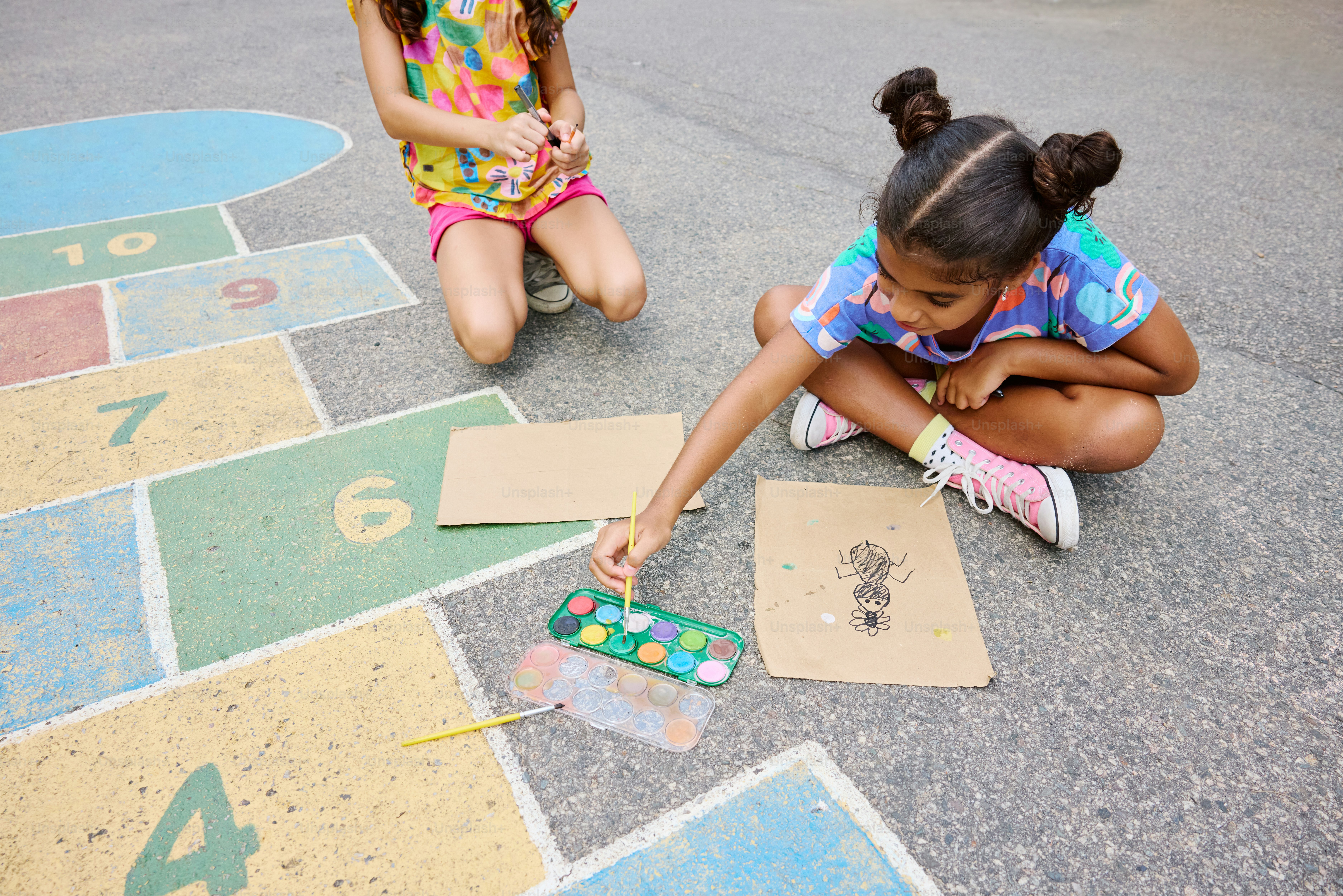 Two young girls sitting on the ground playing with numbers photo ...