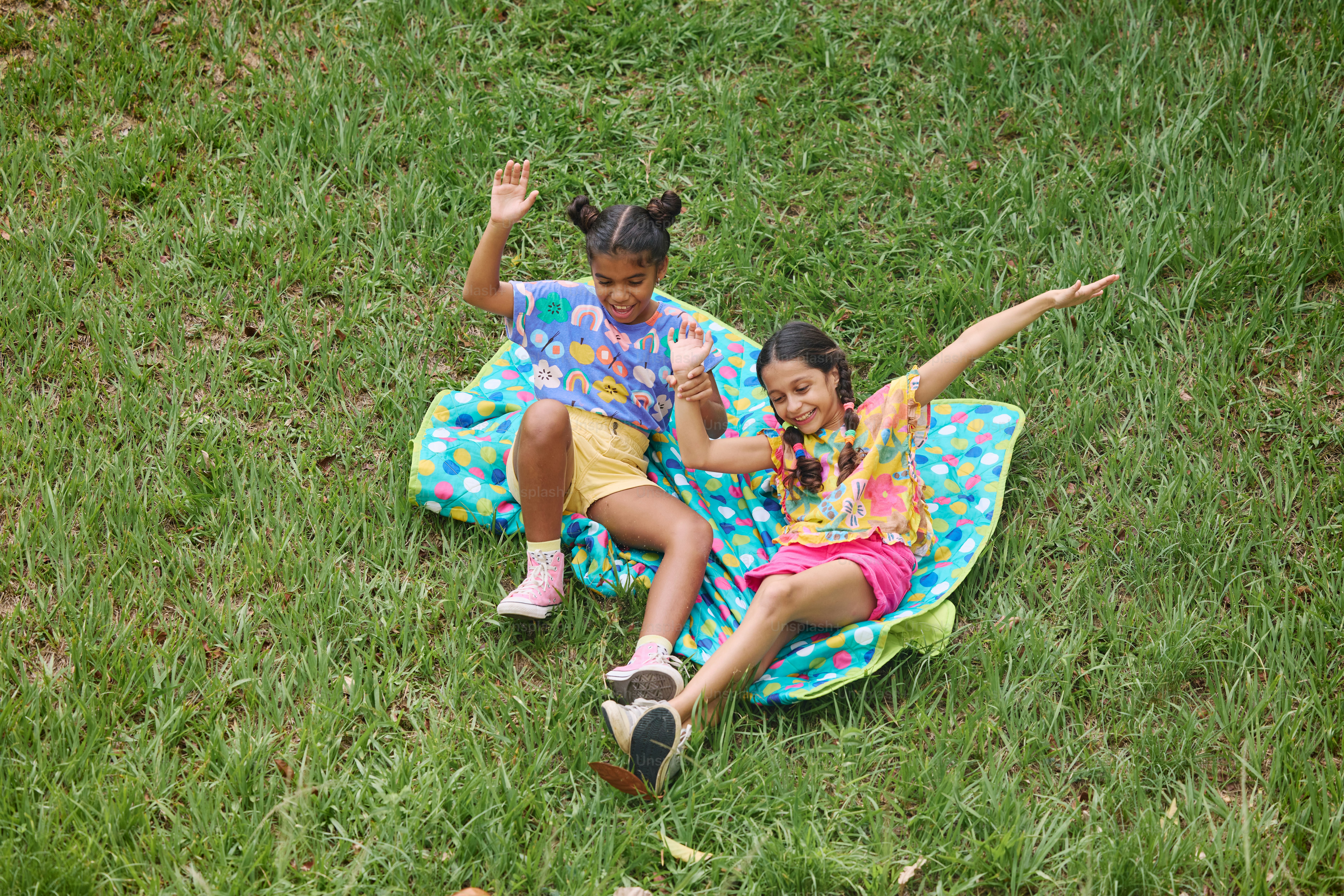 Two girls sitting on a blanket in the grass photo – Tween Image on Unsplash