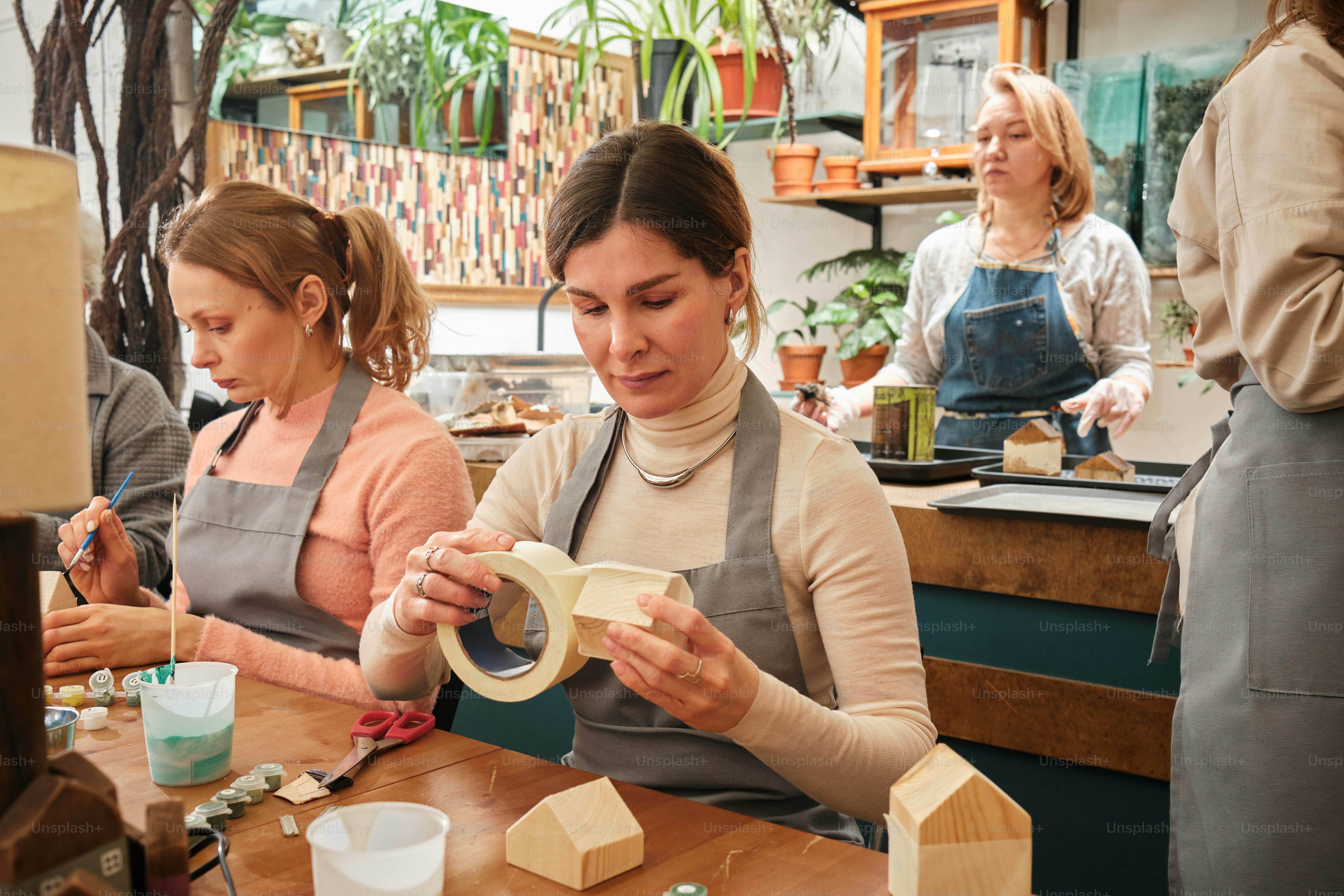 A group of women working on crafts in a shop photo – Decoration Image ...