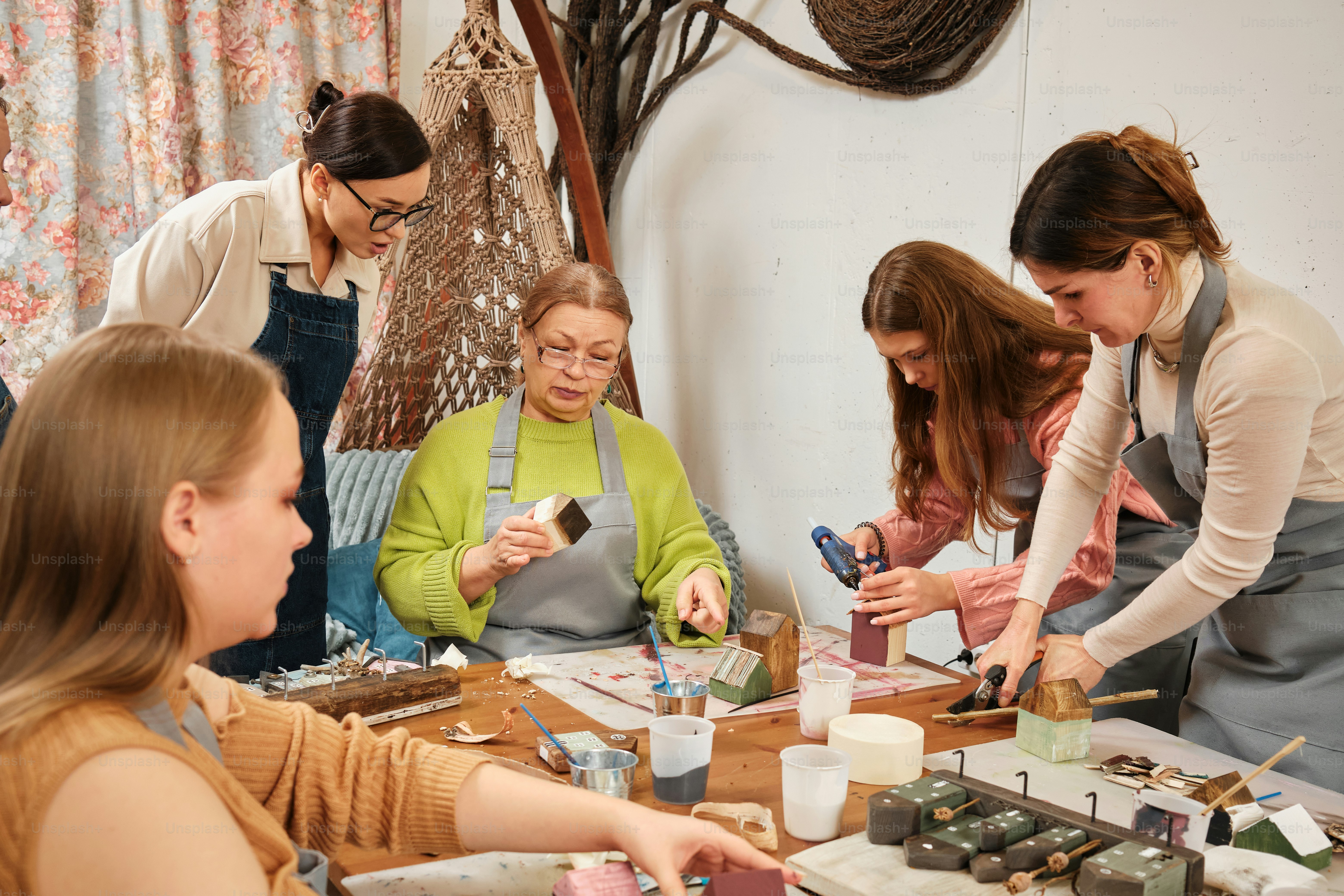 A group of women working on crafts at a table photo – Art class Image ...