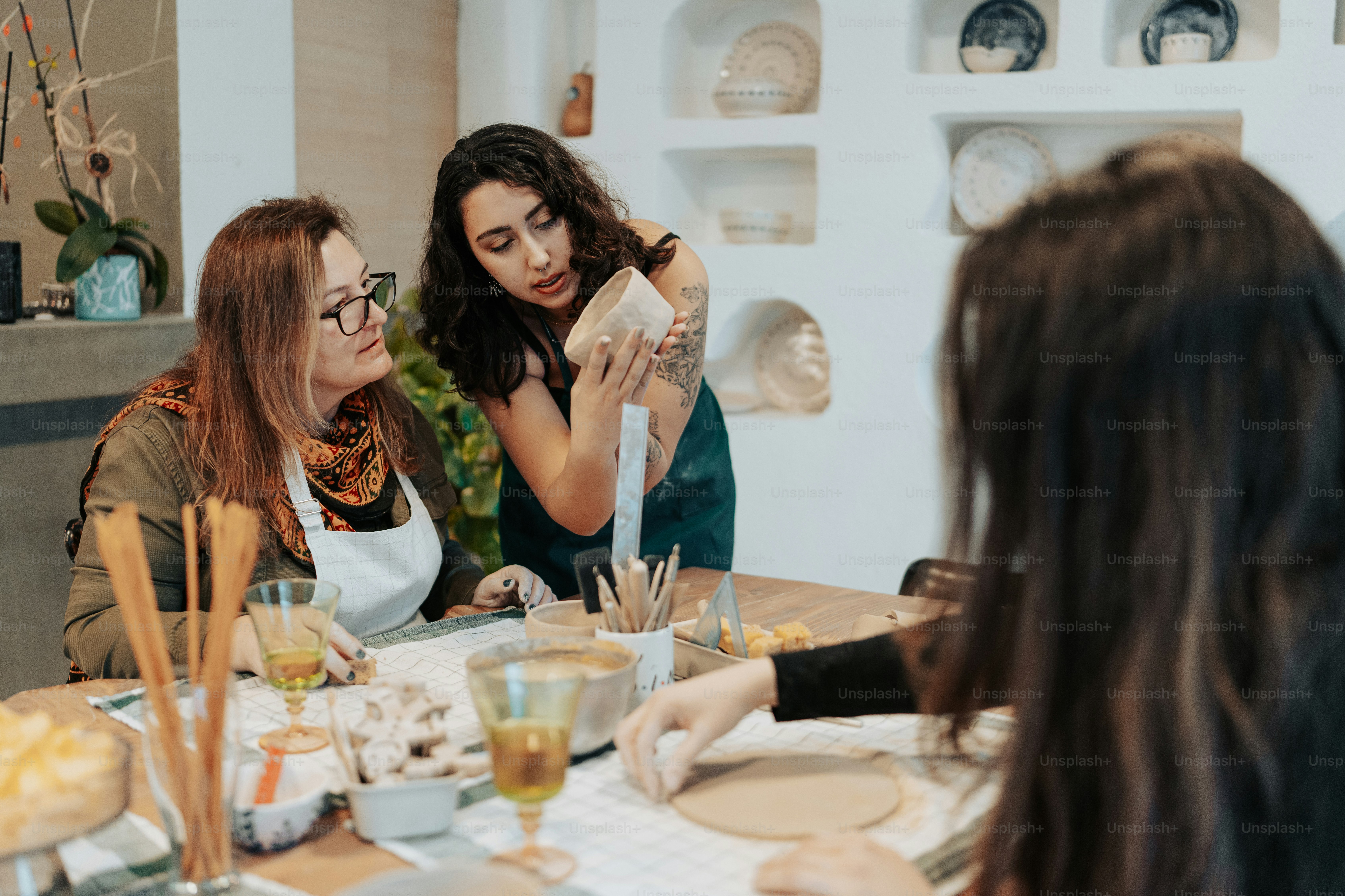 A group of people sitting around a table eating food photo – Workshop ...