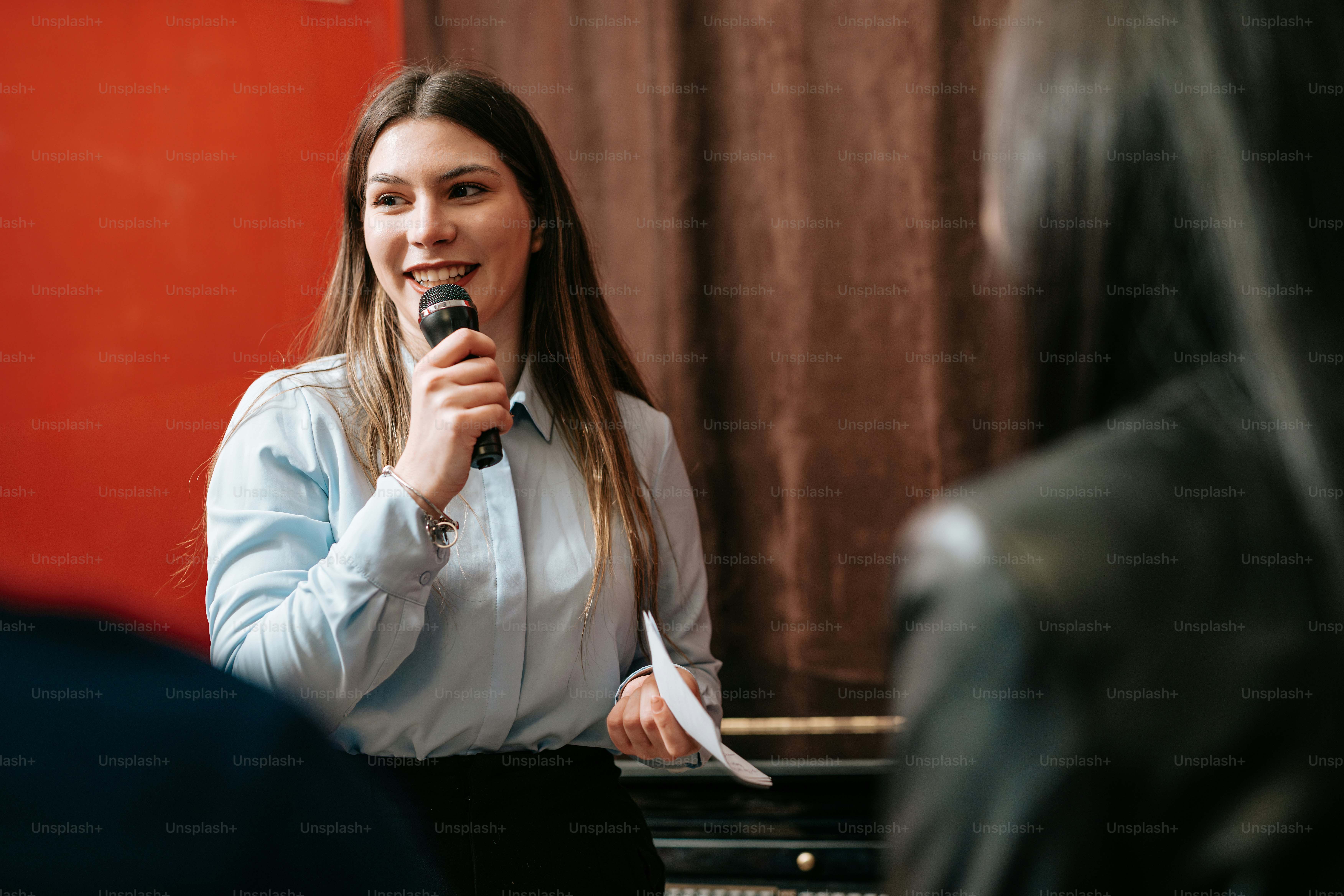 A woman standing in front of a microphone photo – Speaker Image on Unsplash