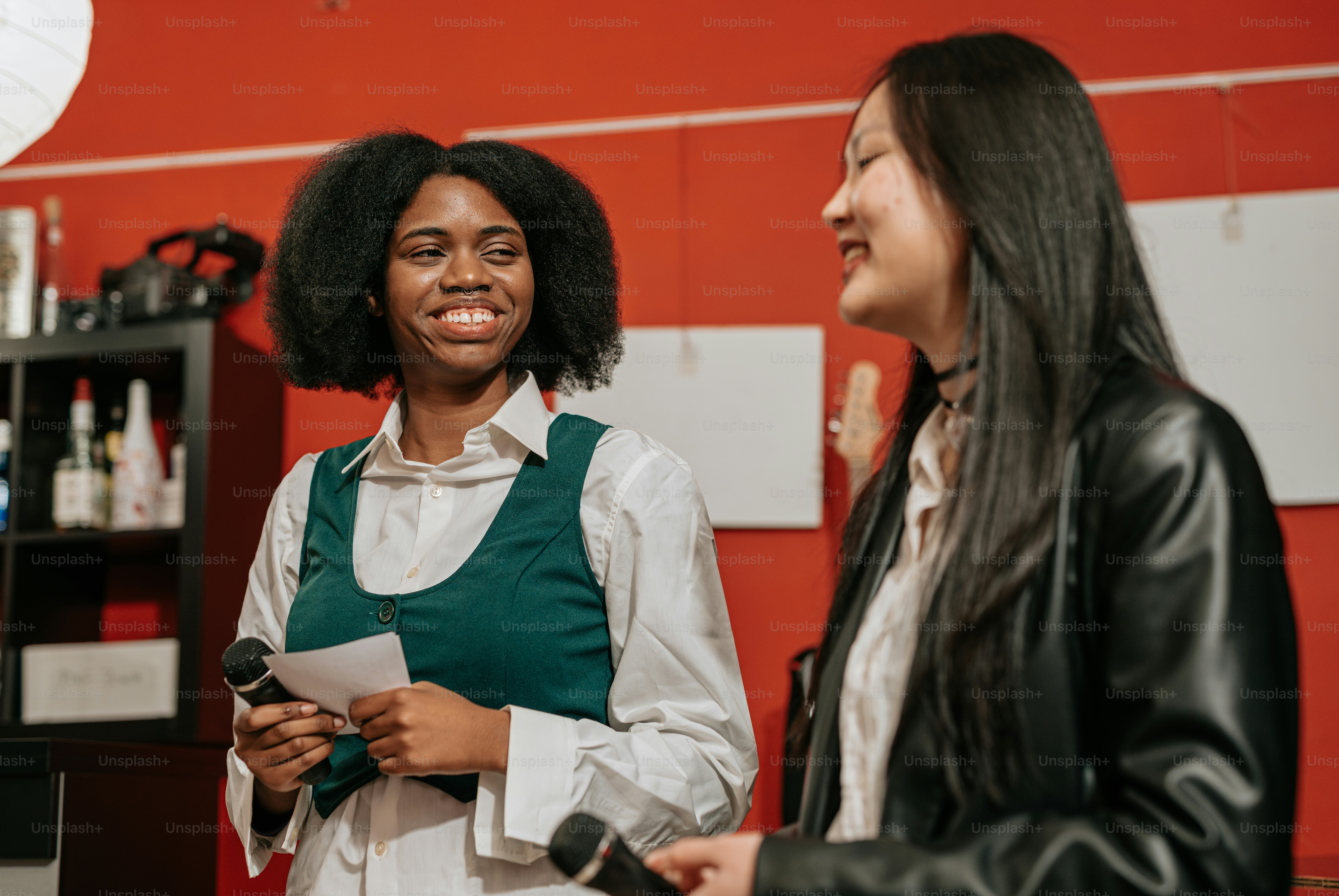 Two women standing in a room talking to each other photo – Spokesperson ...