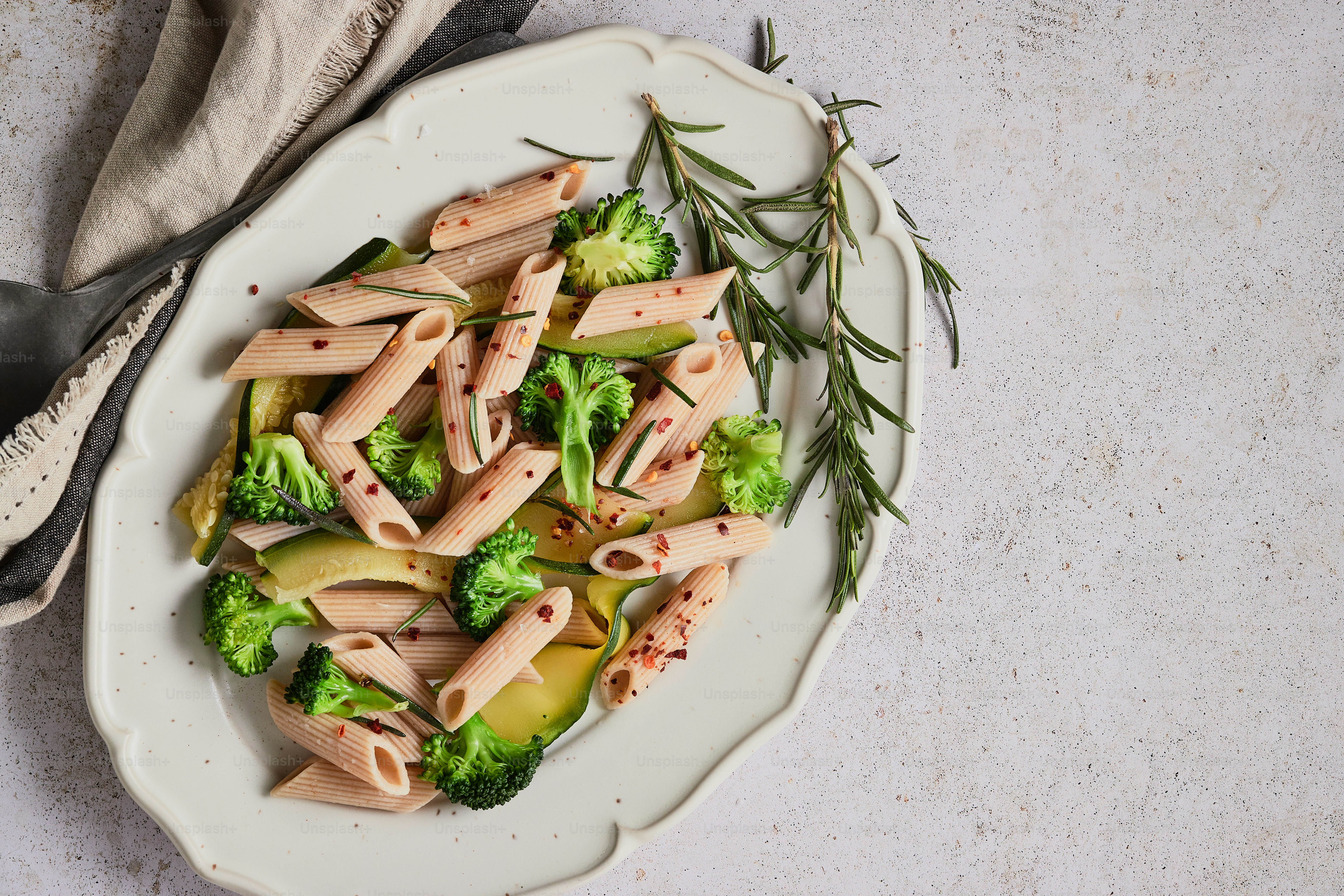 A white plate topped with pasta and broccoli photo – Penne pasta Image ...