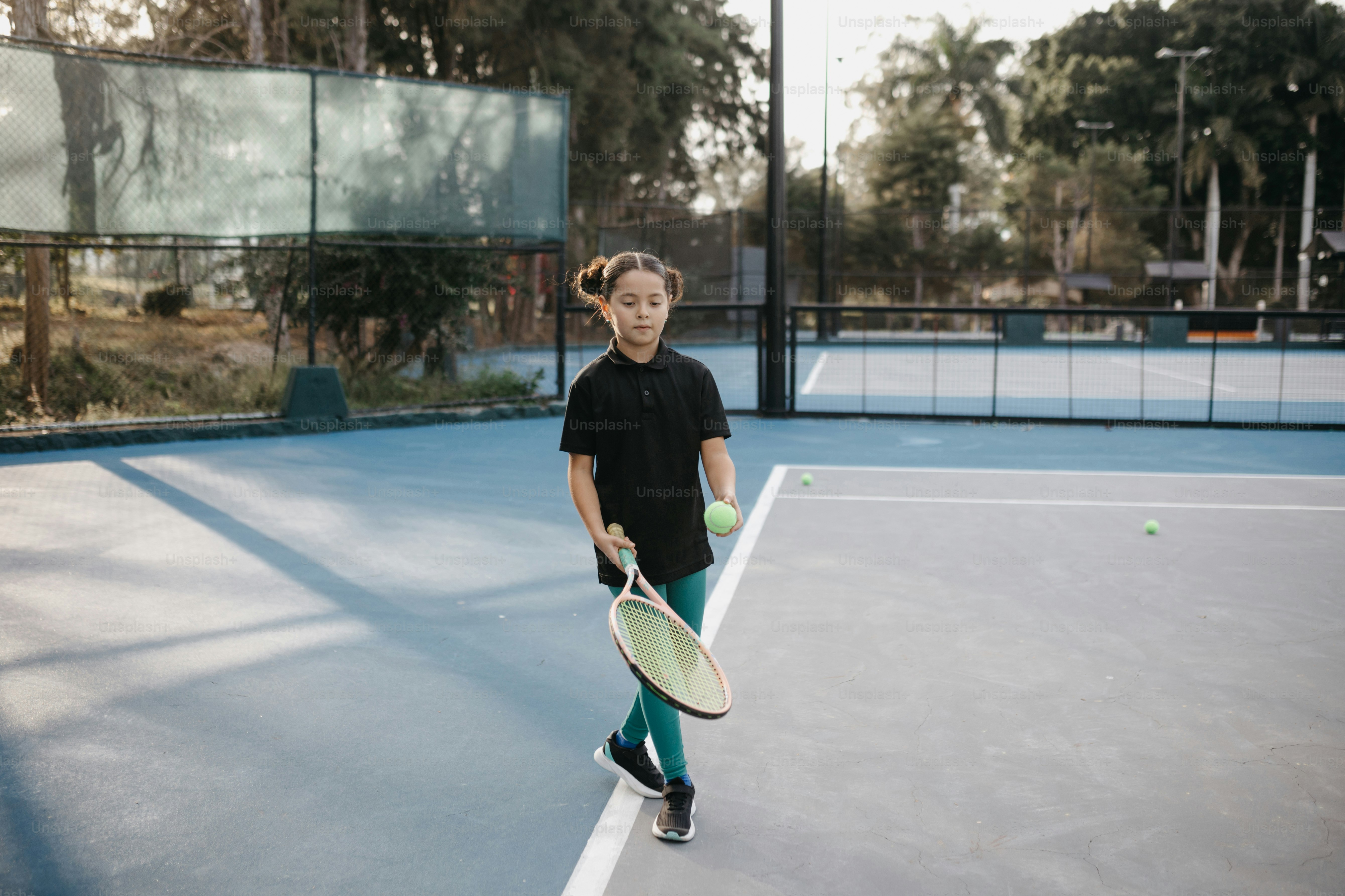 A young boy holding a tennis racquet on a tennis court photo ...