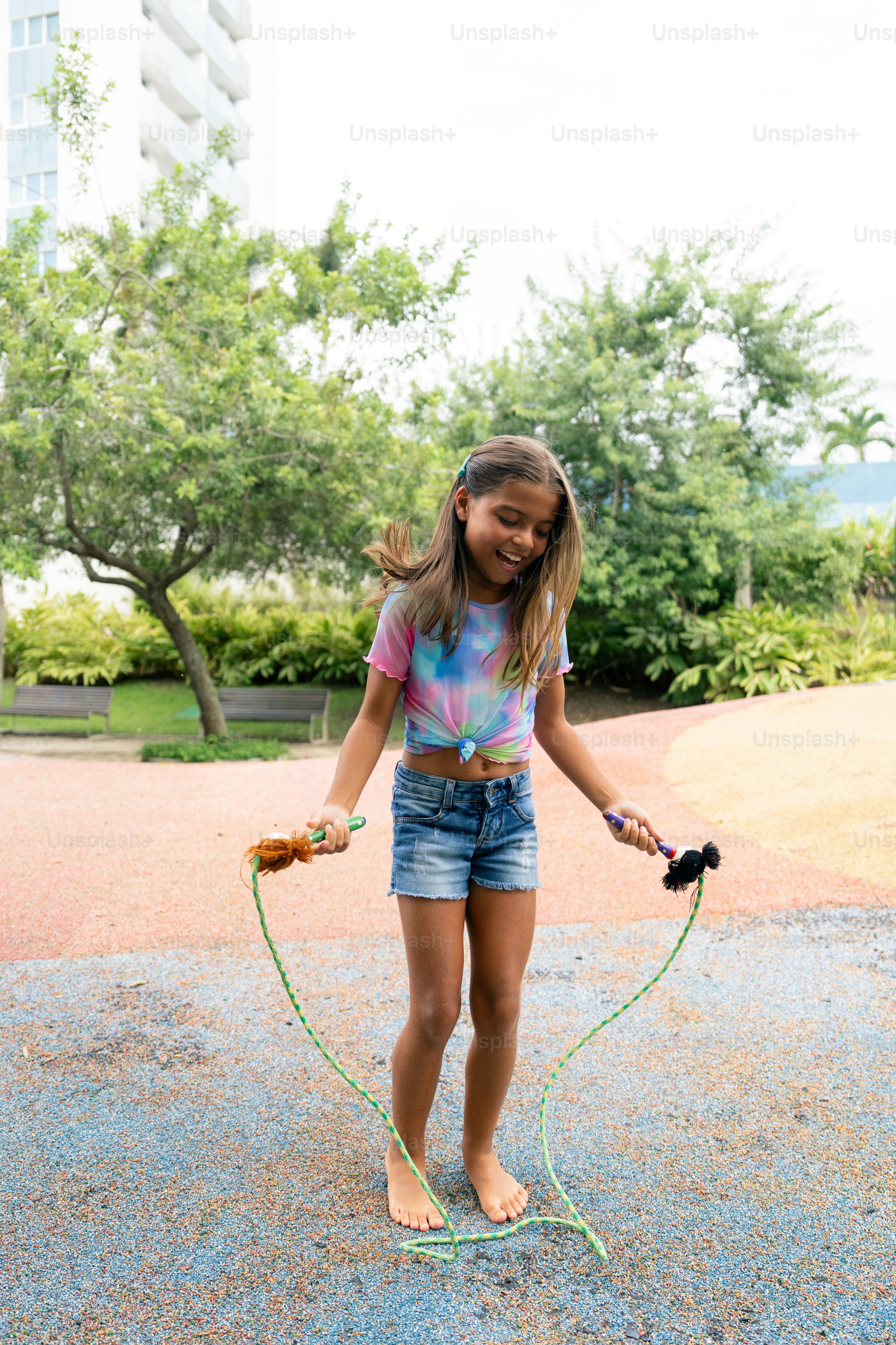 A young girl is holding a rope and smiling photo – Tween Image on Unsplash