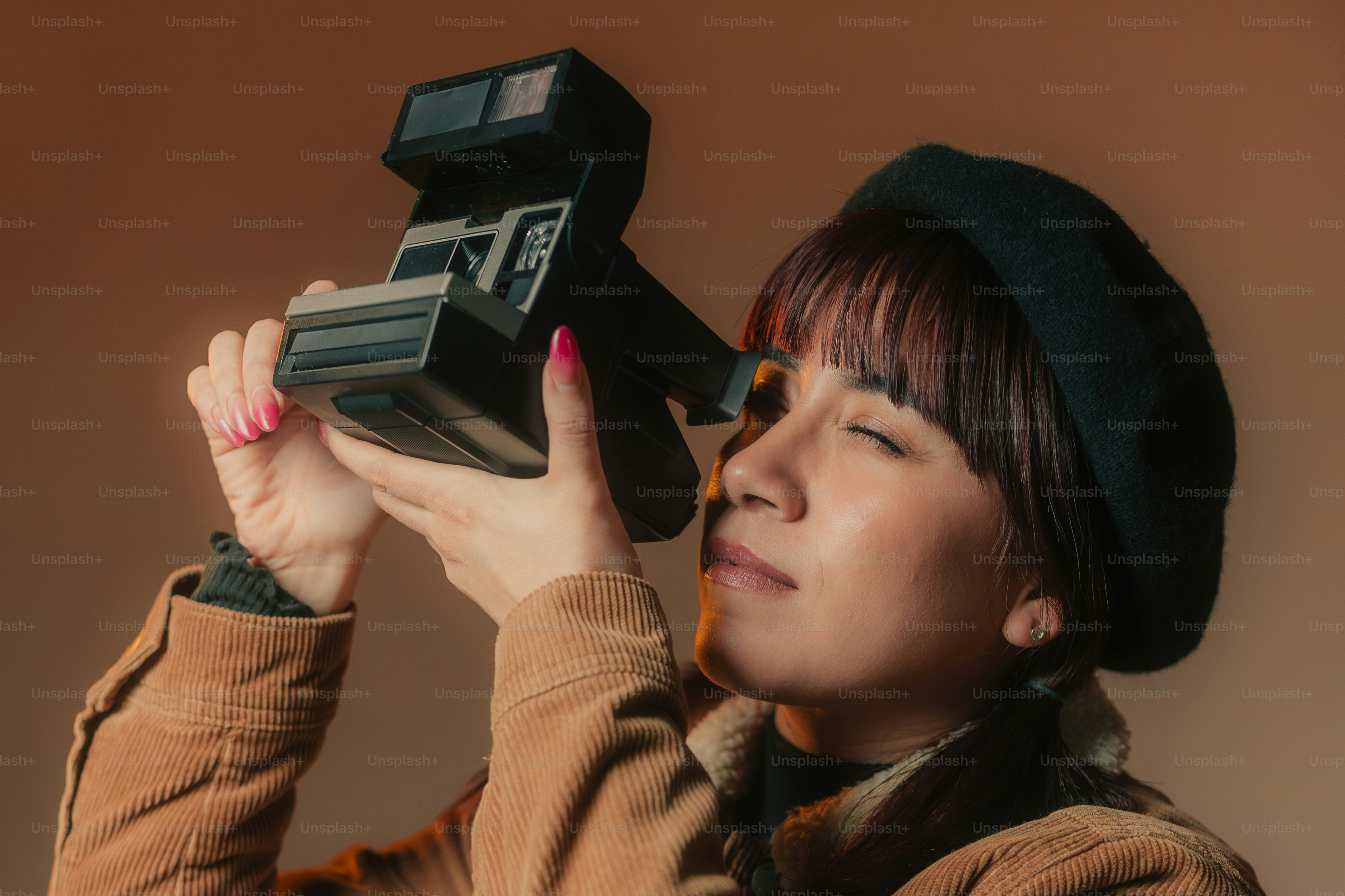 A woman holding a camera up to her face photo – Polaroid Image on Unsplash
