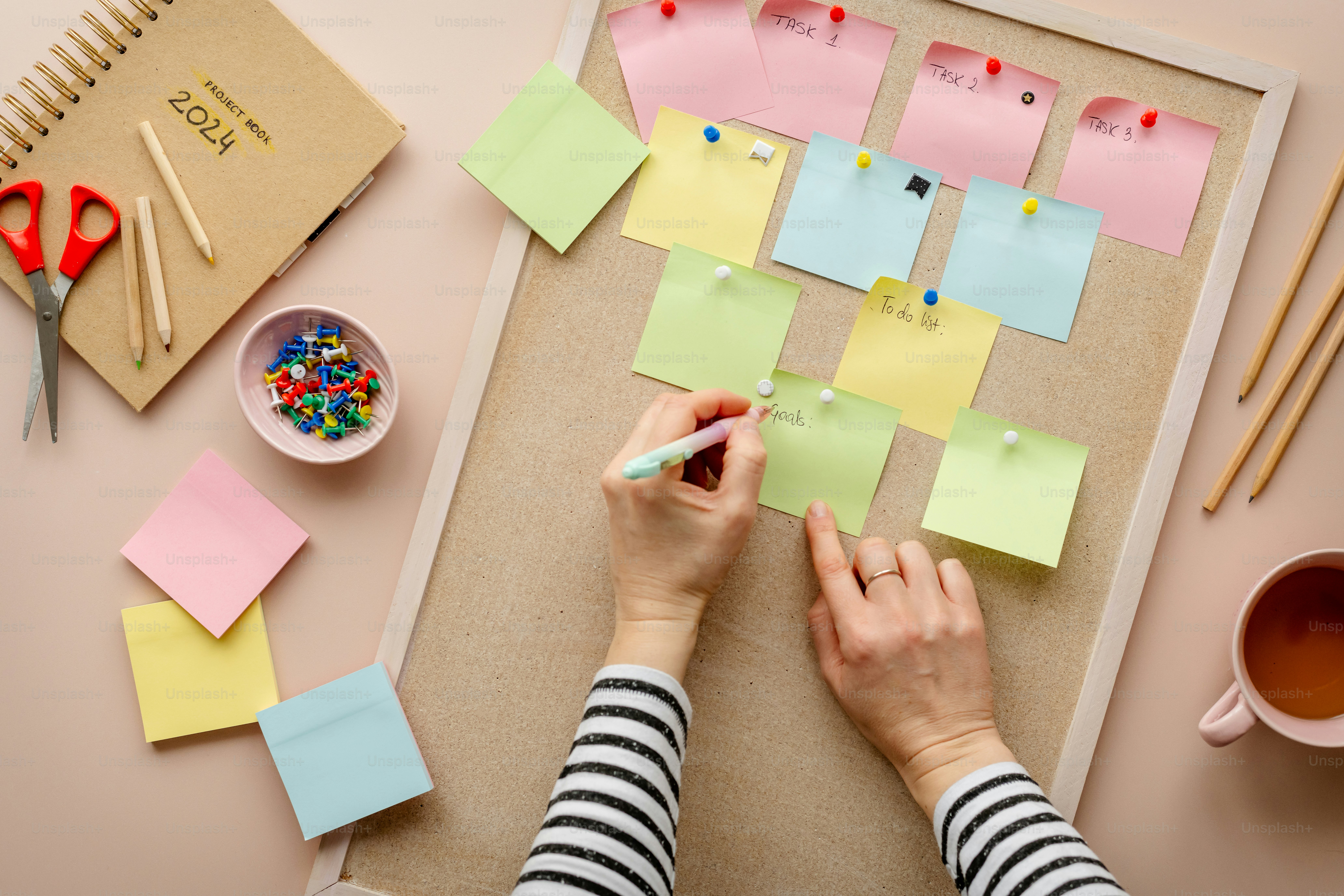 A person is making a post it note on a bulletin board photo – Schedule ...