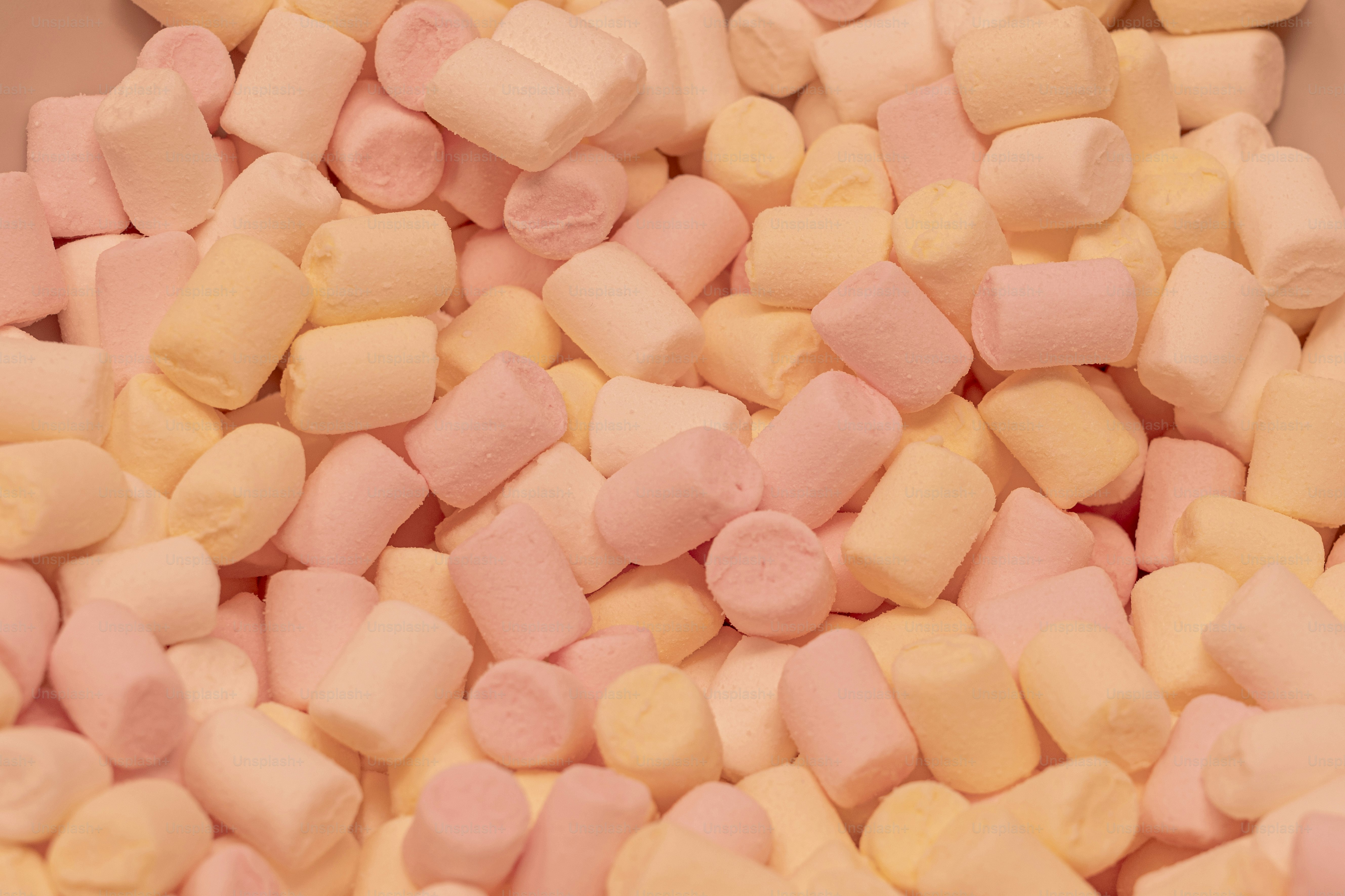 A bowl filled with marshmallows on top of a table photo – Peach pink ...
