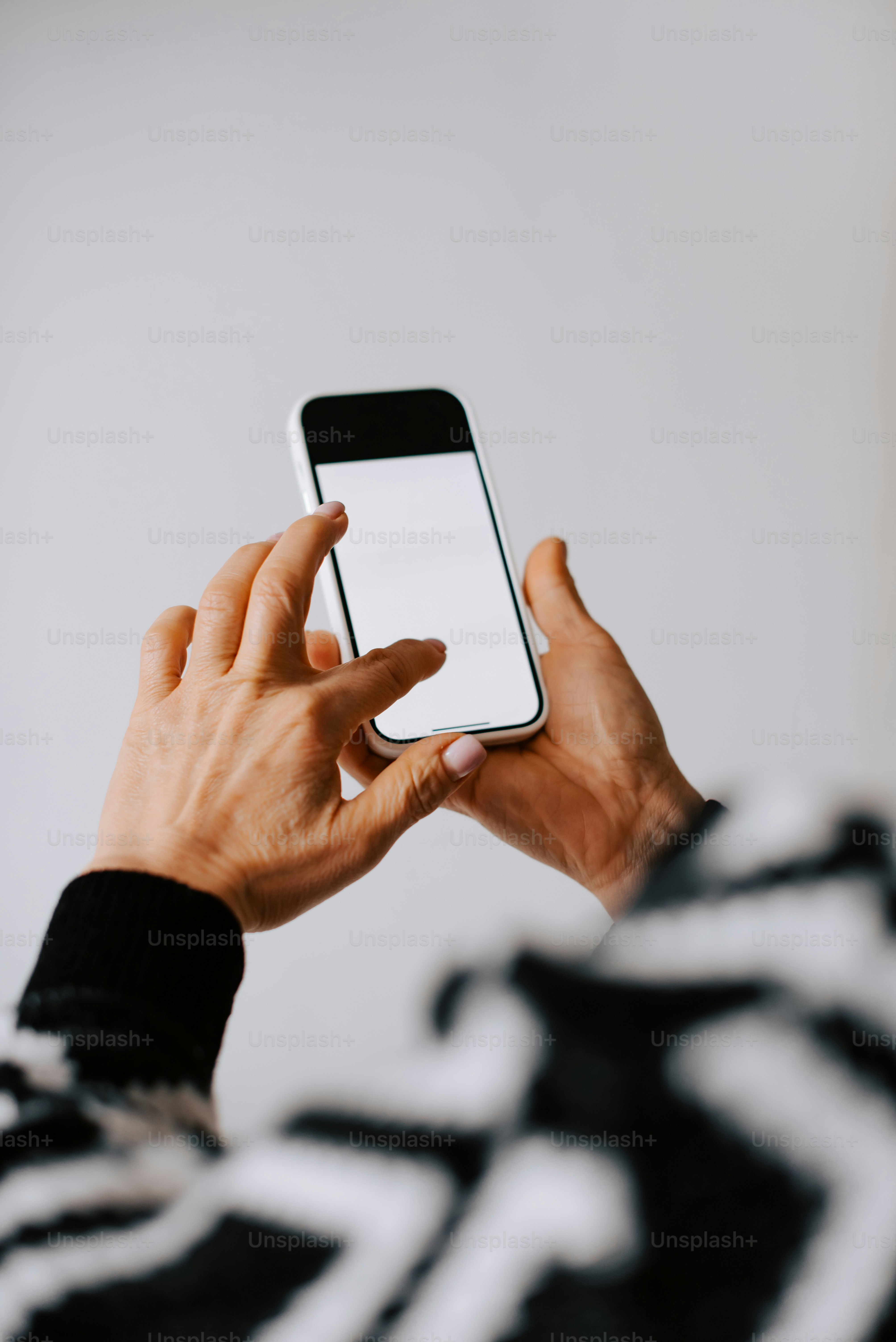 A person sitting on a couch holding a cell phone photo – Mobile phone ...