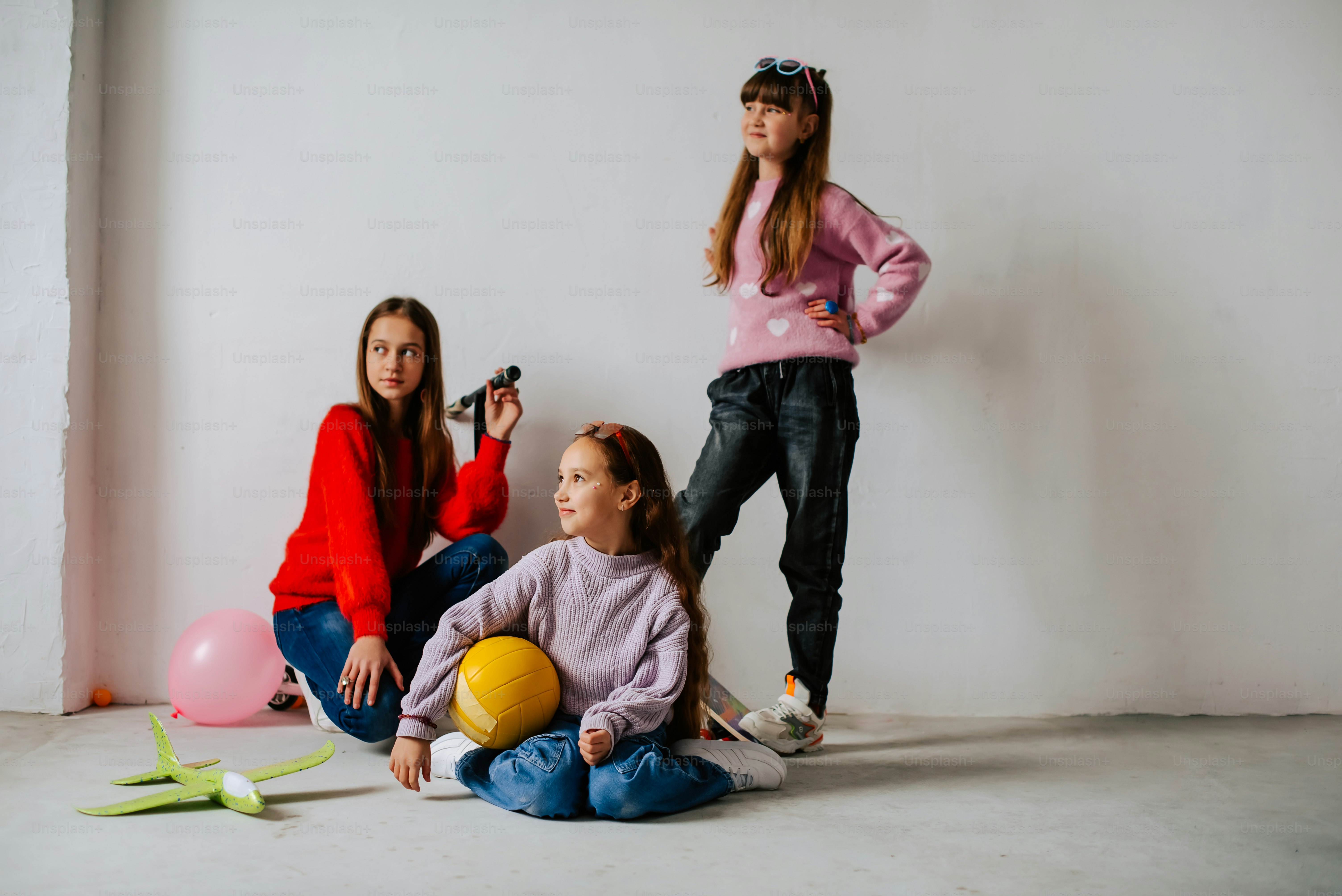 Two young girls sitting on the floor with a ball photo – Playing ...