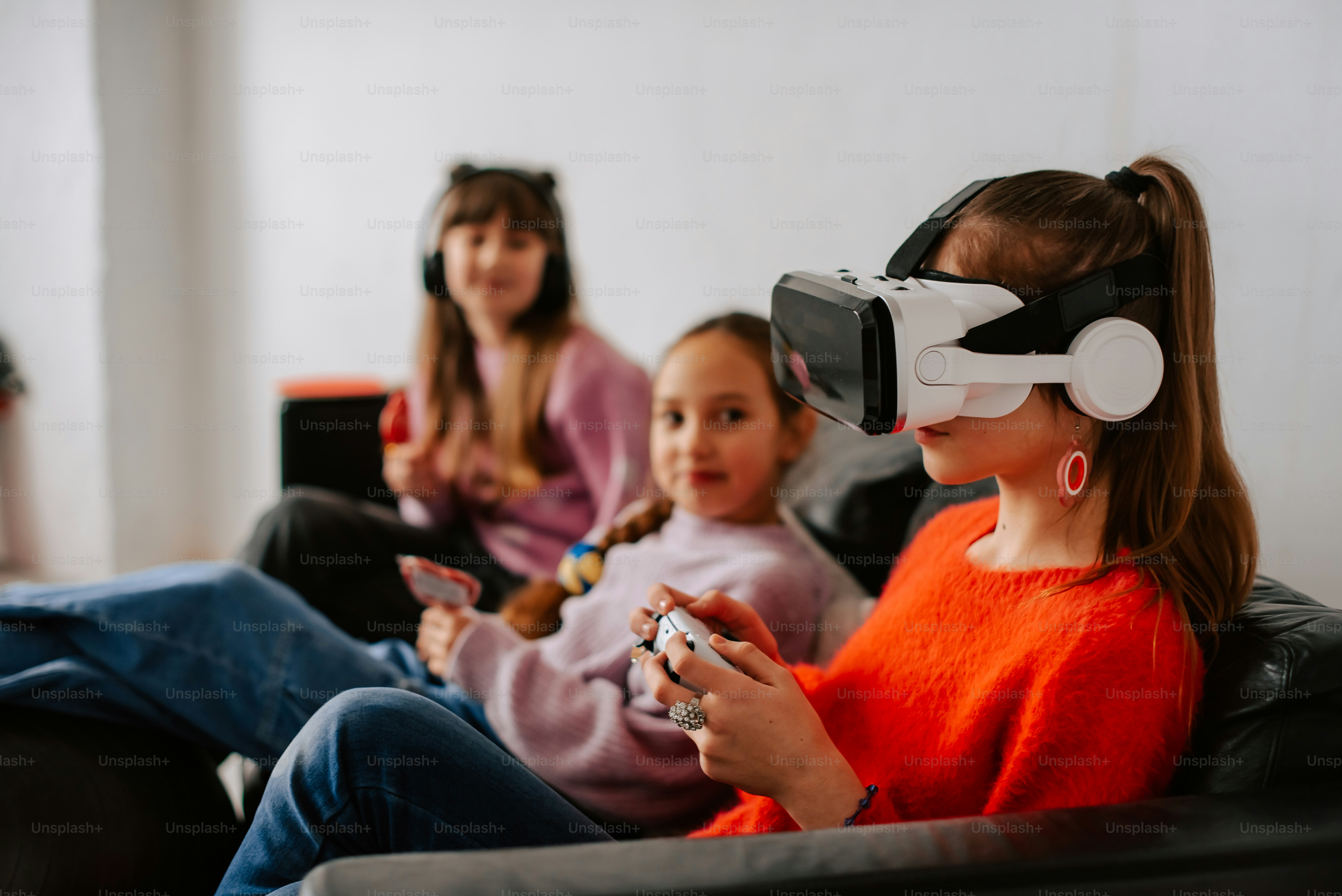 A group of people sitting on a couch with remotes photo – Vr headset ...