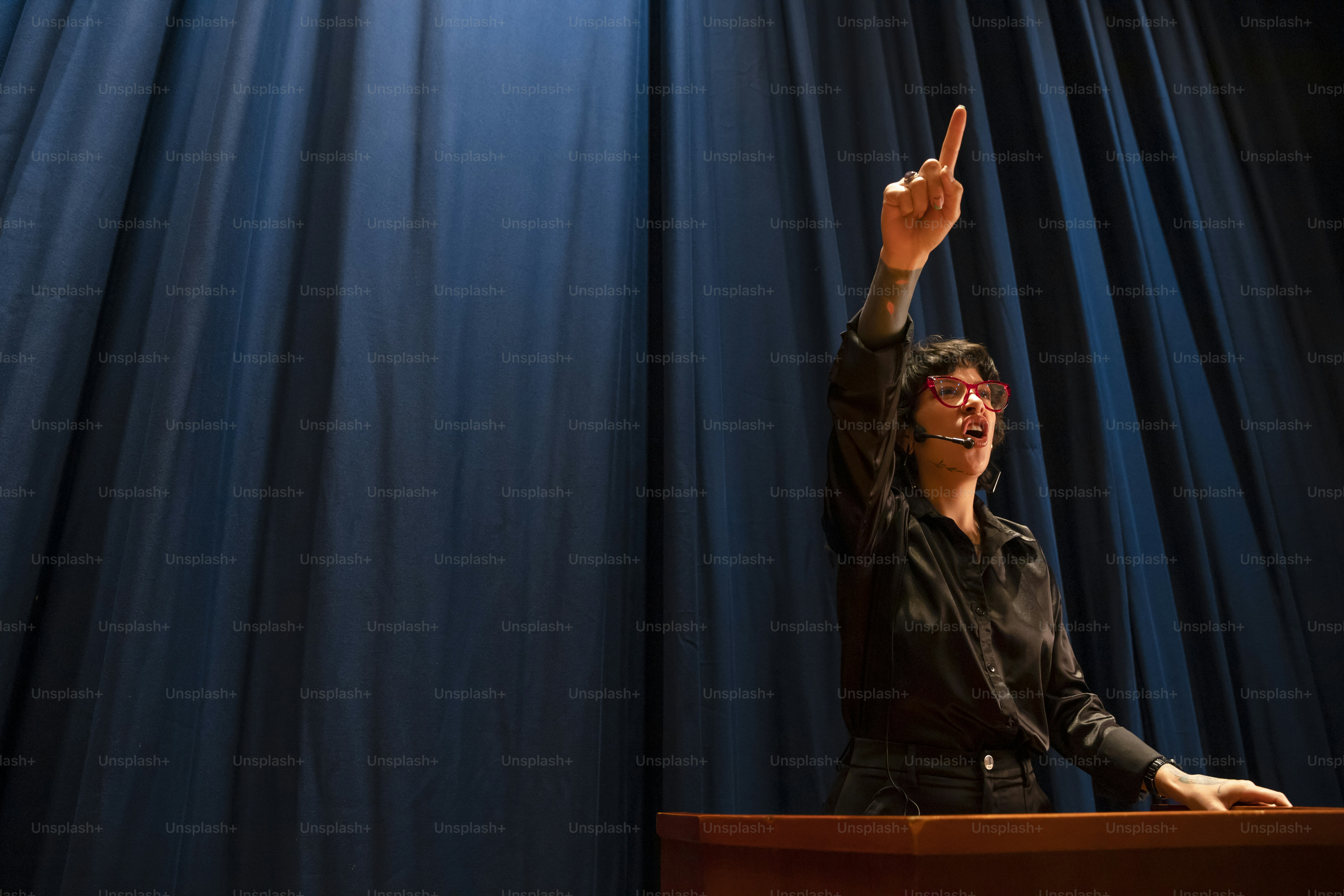 A woman giving a speech at a podium photo – Public speaker Image on ...