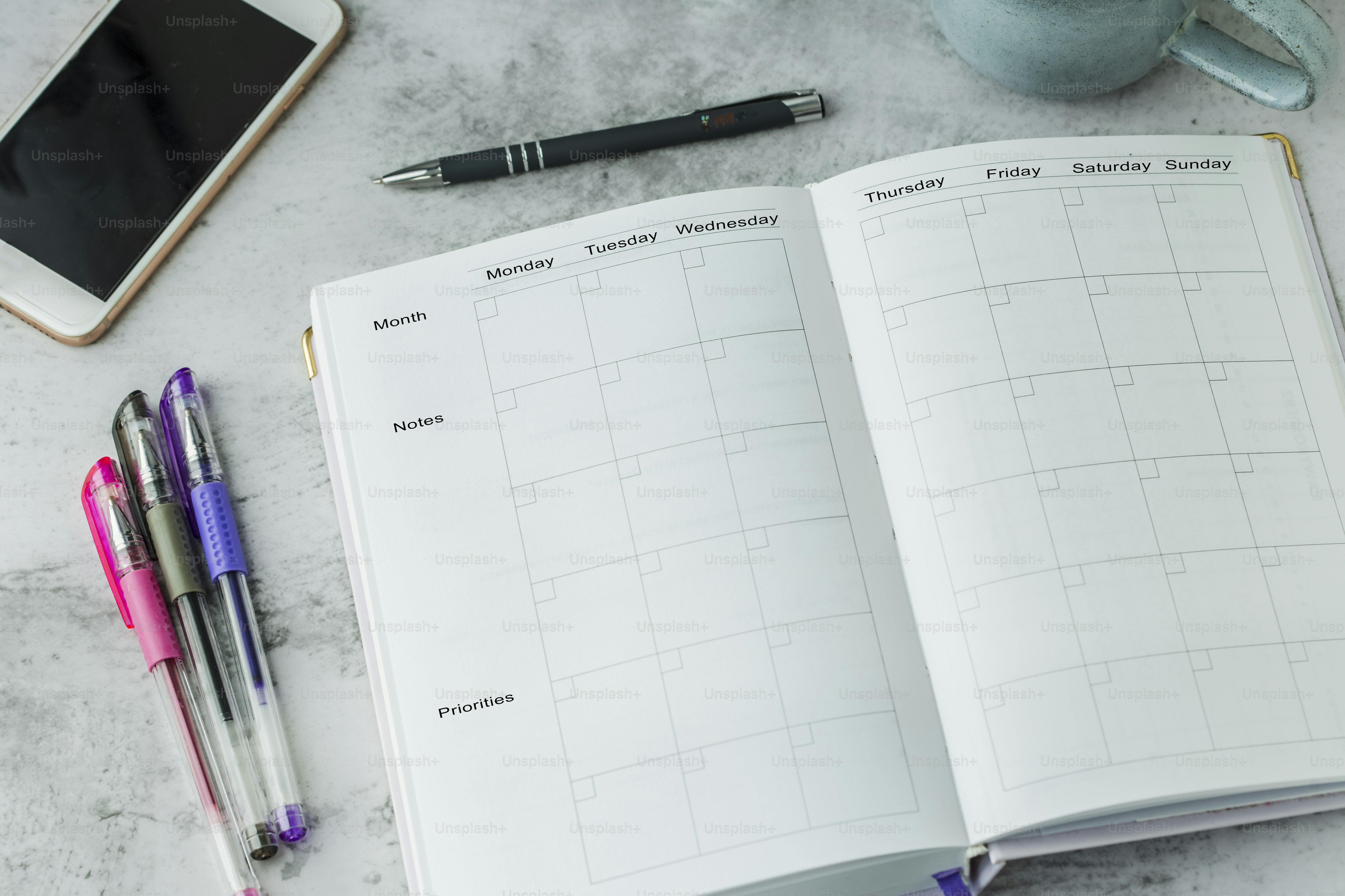 A desk with a calendar, pens, and other office supplies photo ...