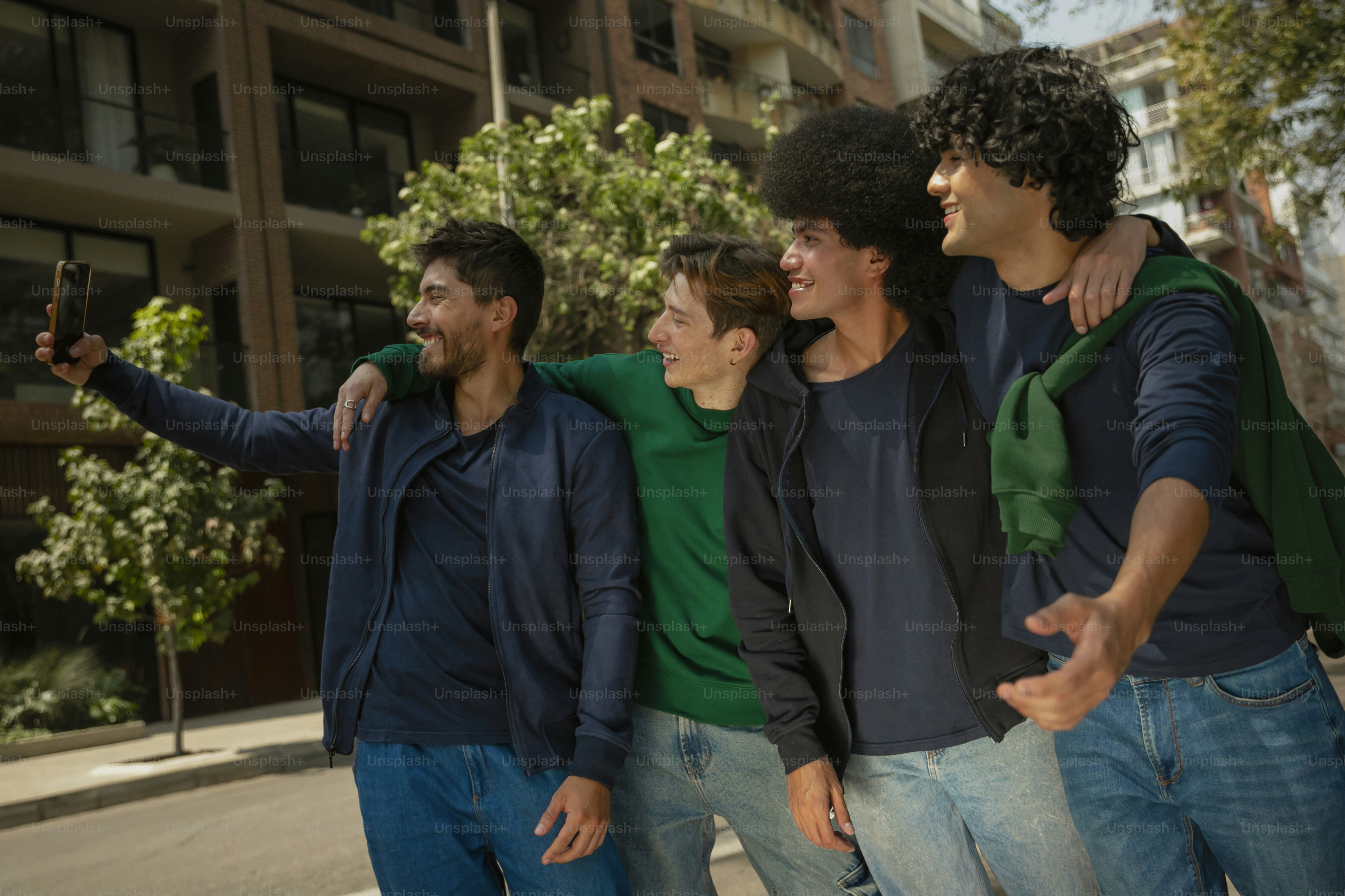 A group of young men sitting next to each other photo – Hoodie Image on ...