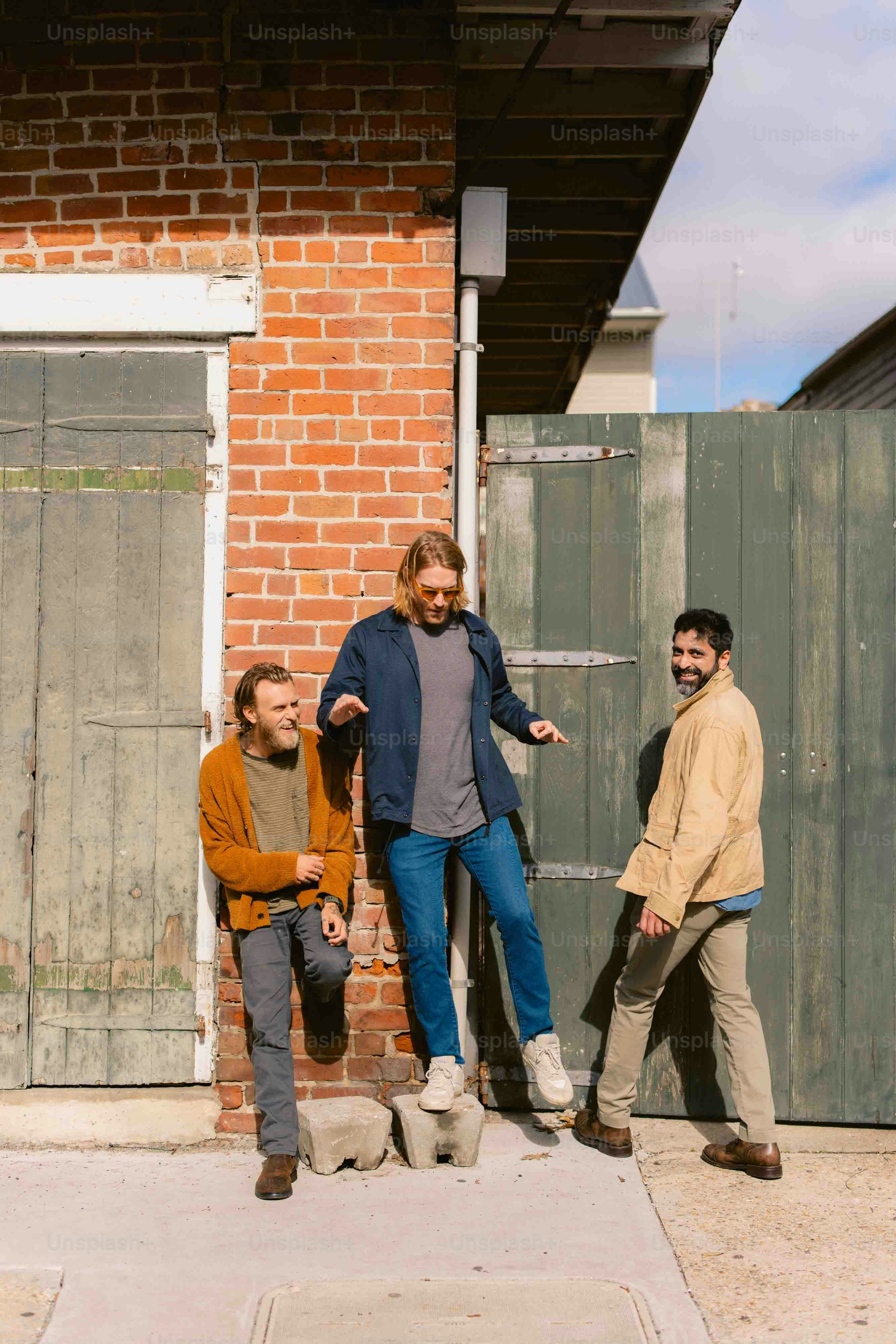 A group of three men sitting next to each other photo – Friends Image ...