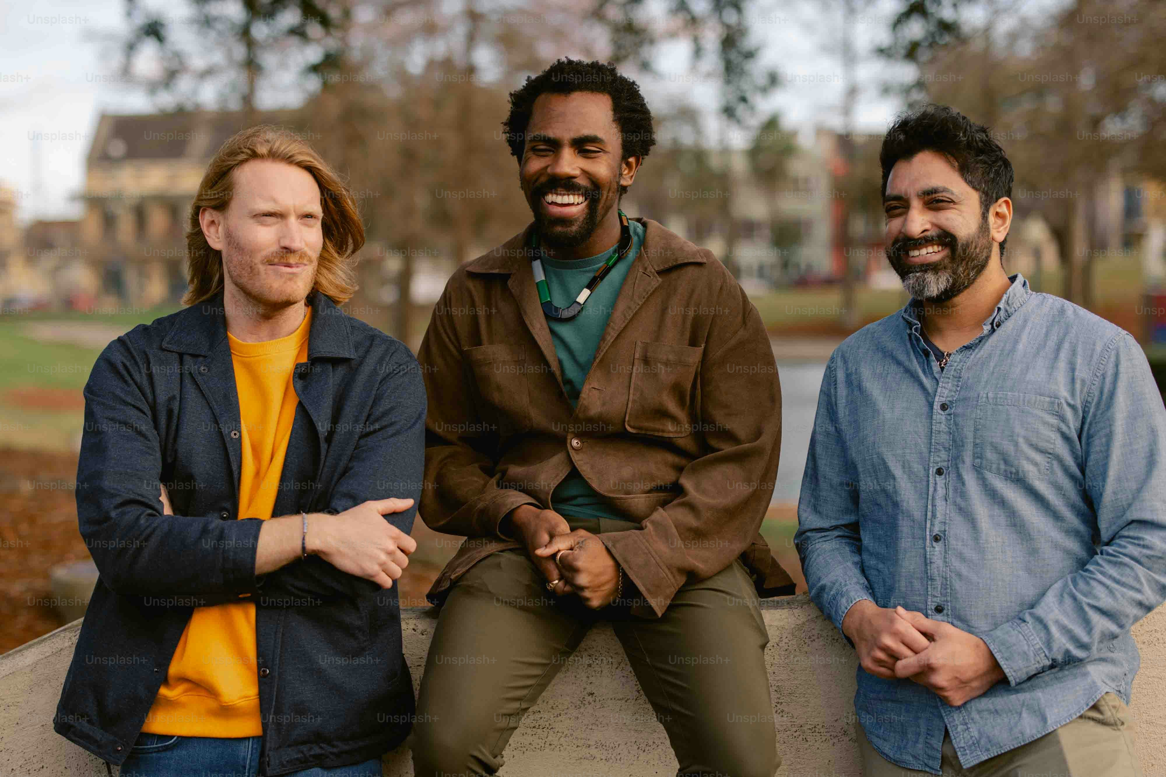 A group of three men sitting next to each other photo – Friends Image ...