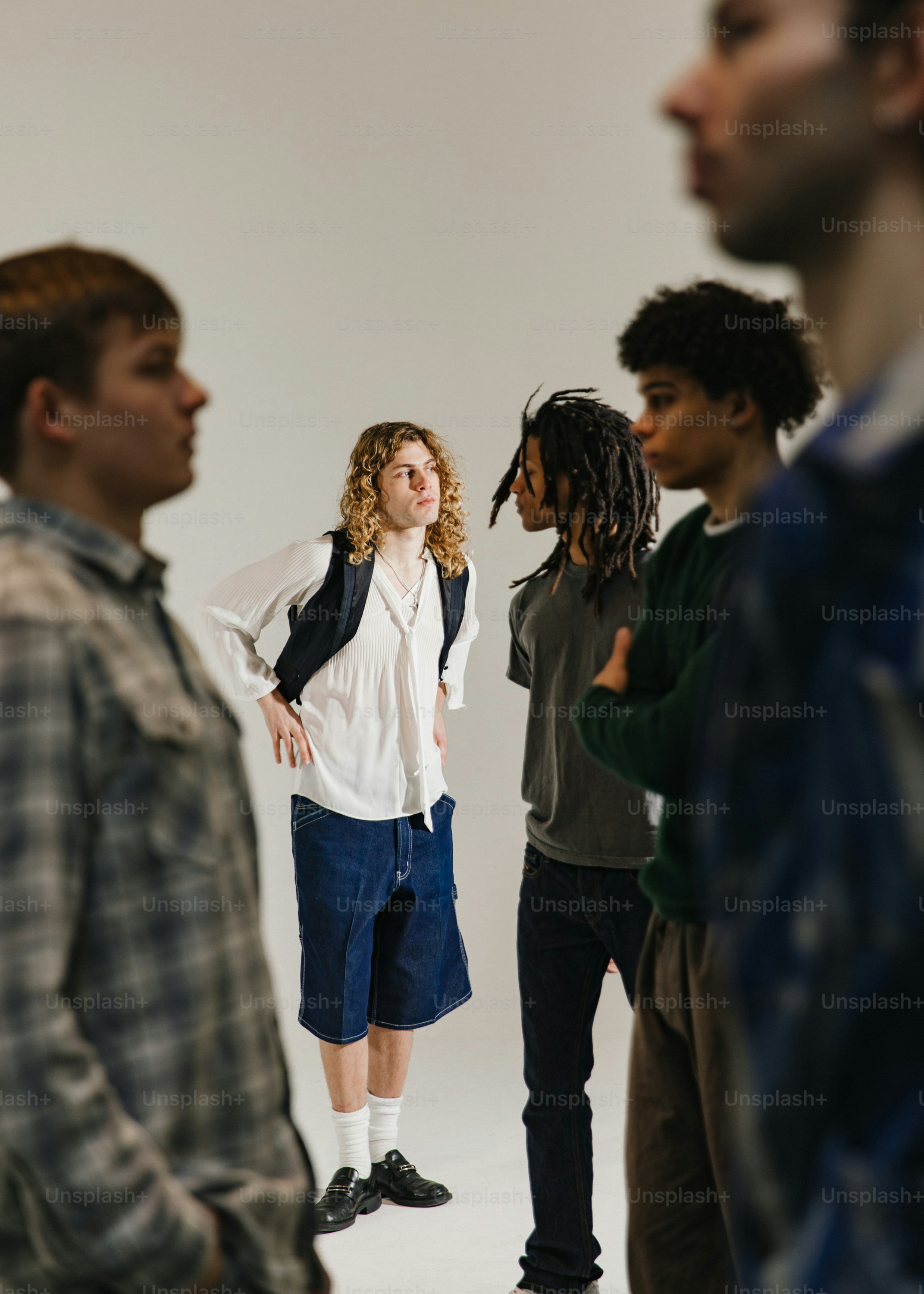 A group of young men standing next to each other photo – Mens fashion ...