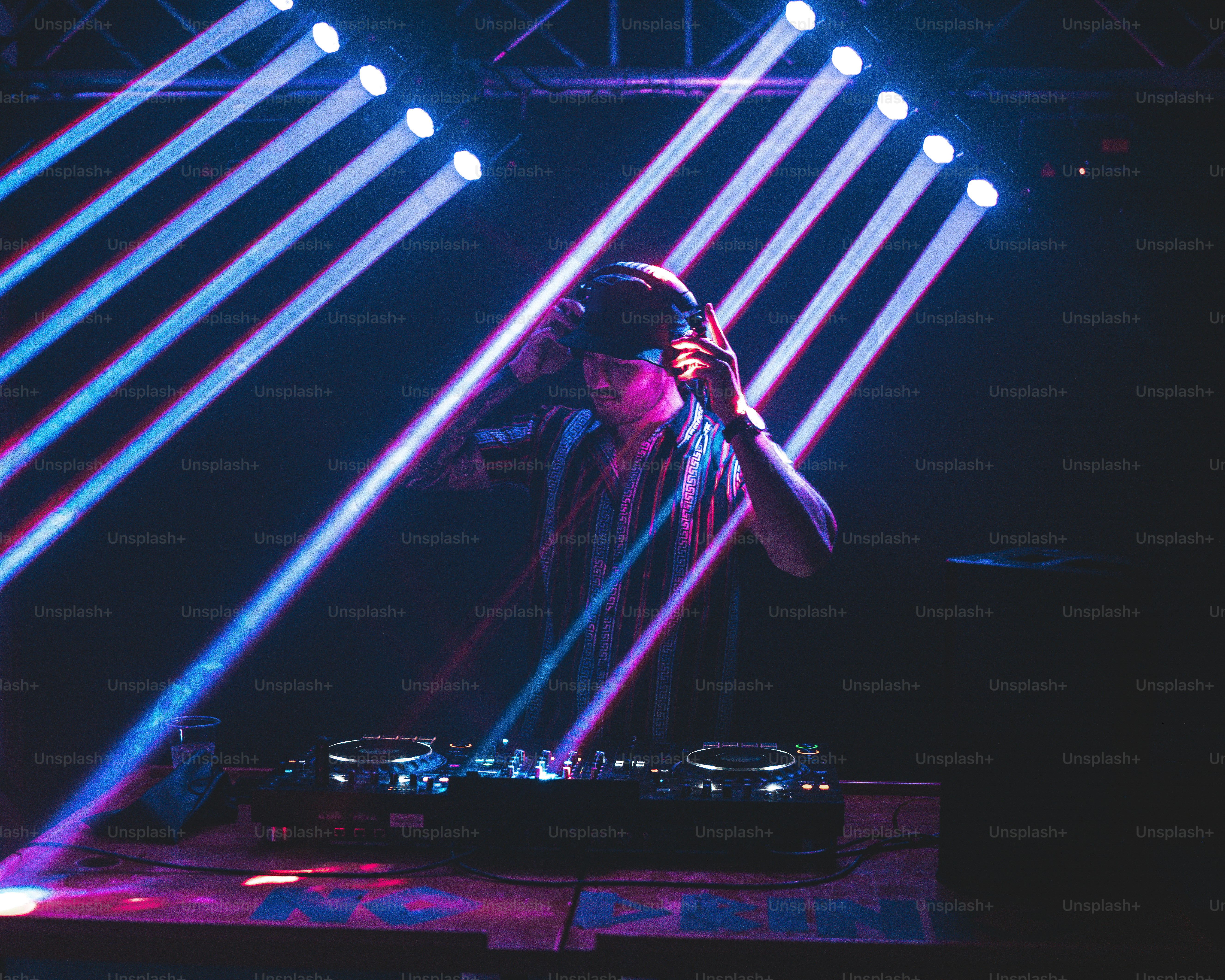 A dj mixing on a stage with a lot of lights photo – Dj Image on Unsplash