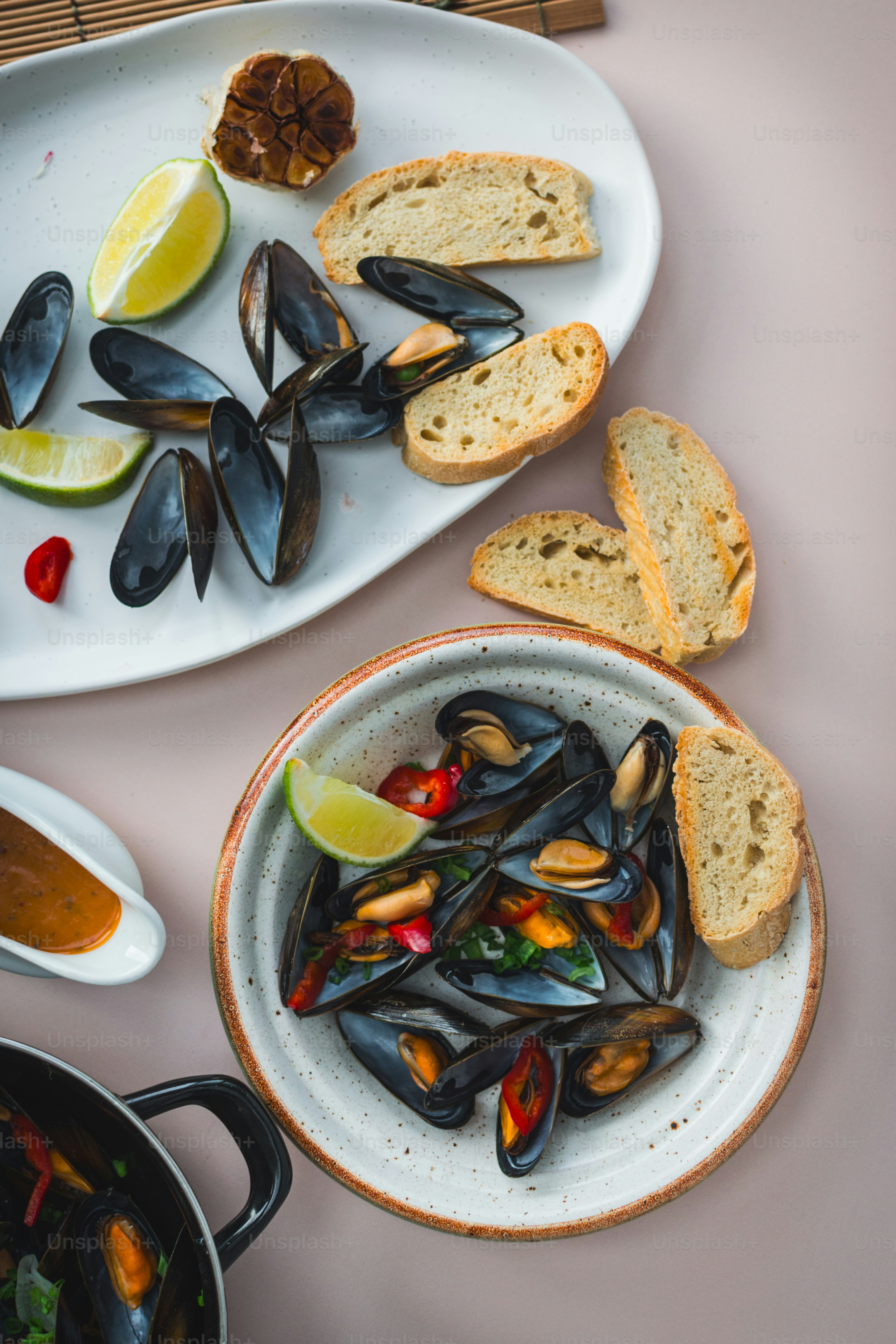 A plate of mussels and bread on a table photo – Food photography Image ...
