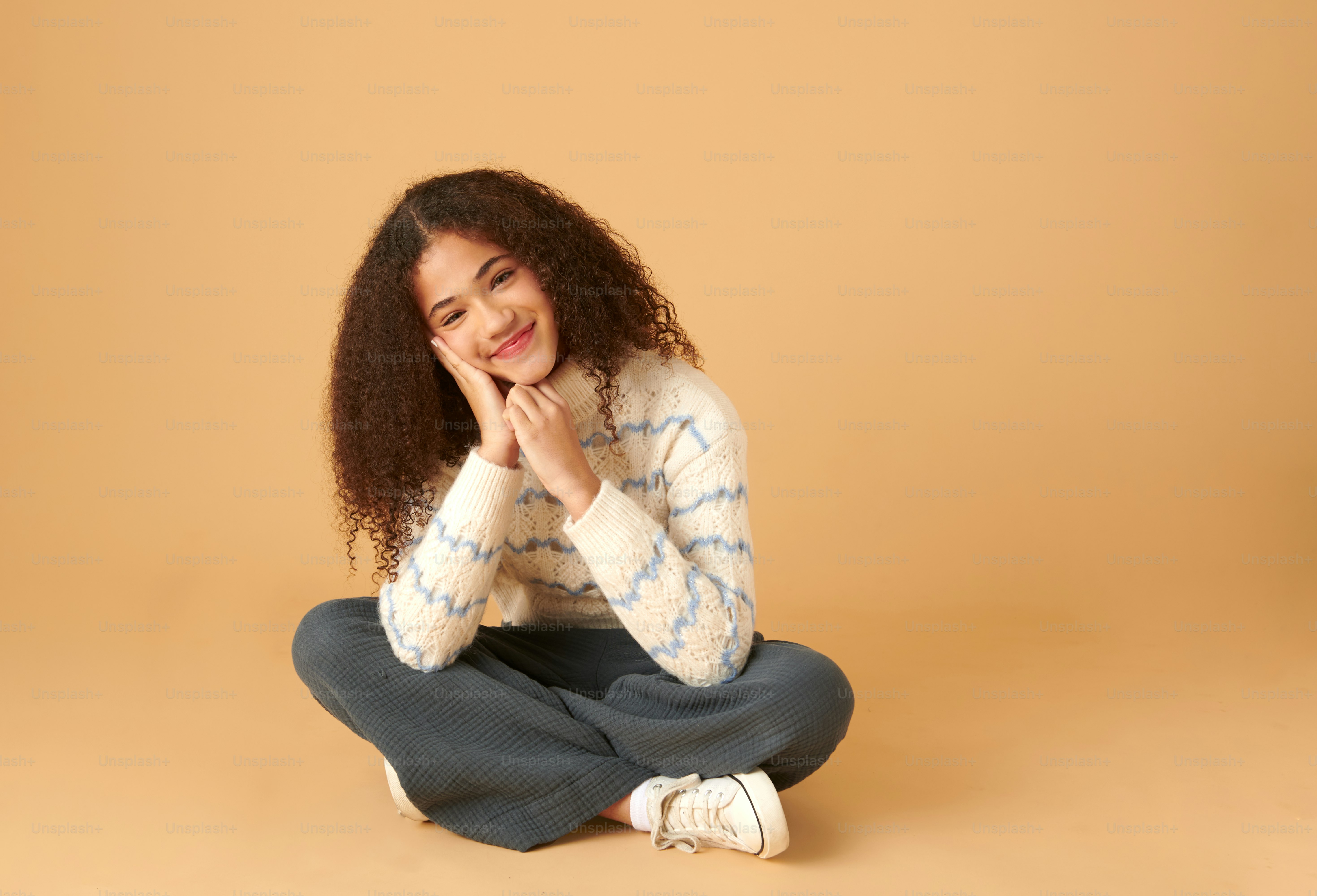A young woman sitting on the floor smiling photo – Tween Image on Unsplash