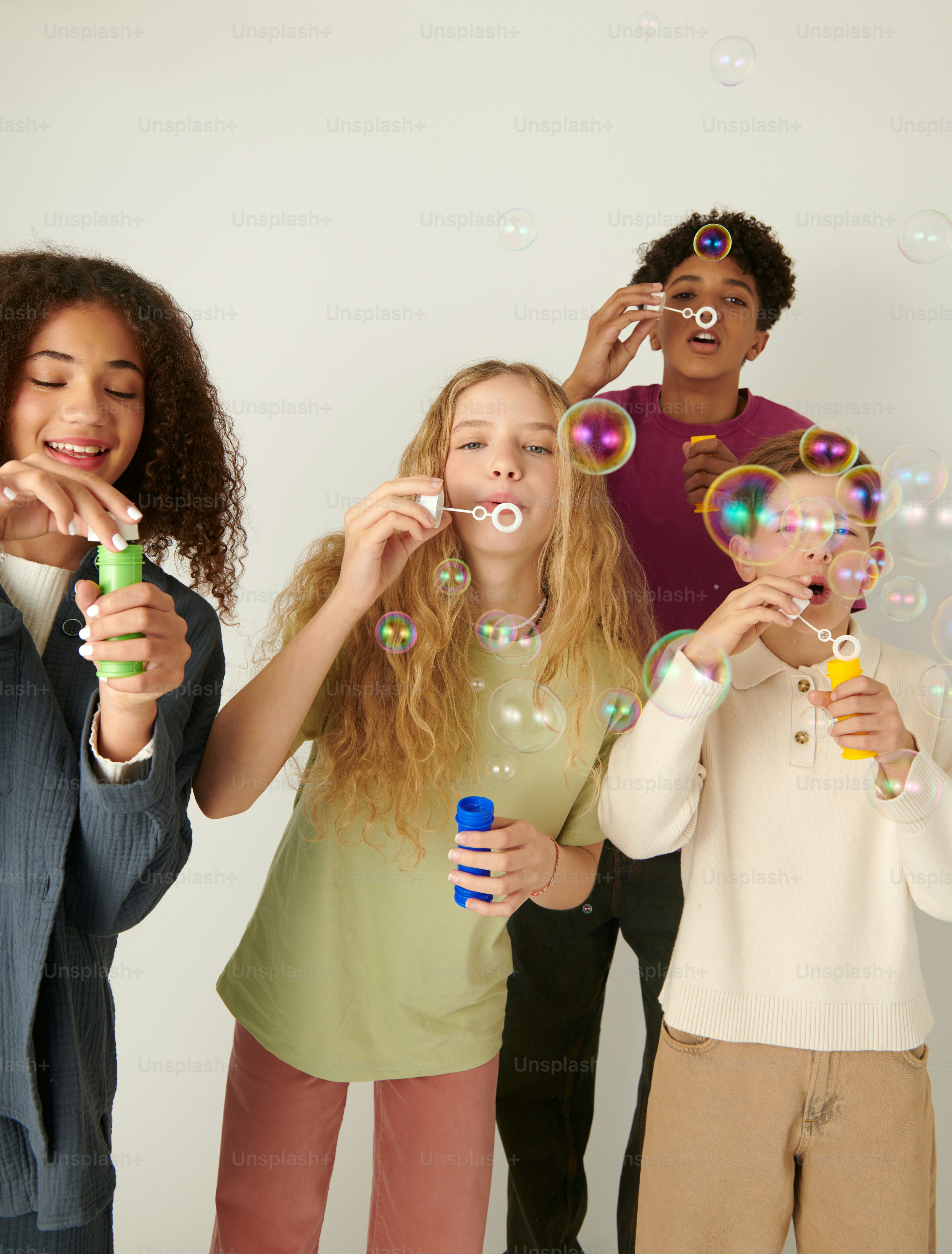 A group of people blowing bubbles in the air photo – Blowing bubbles ...