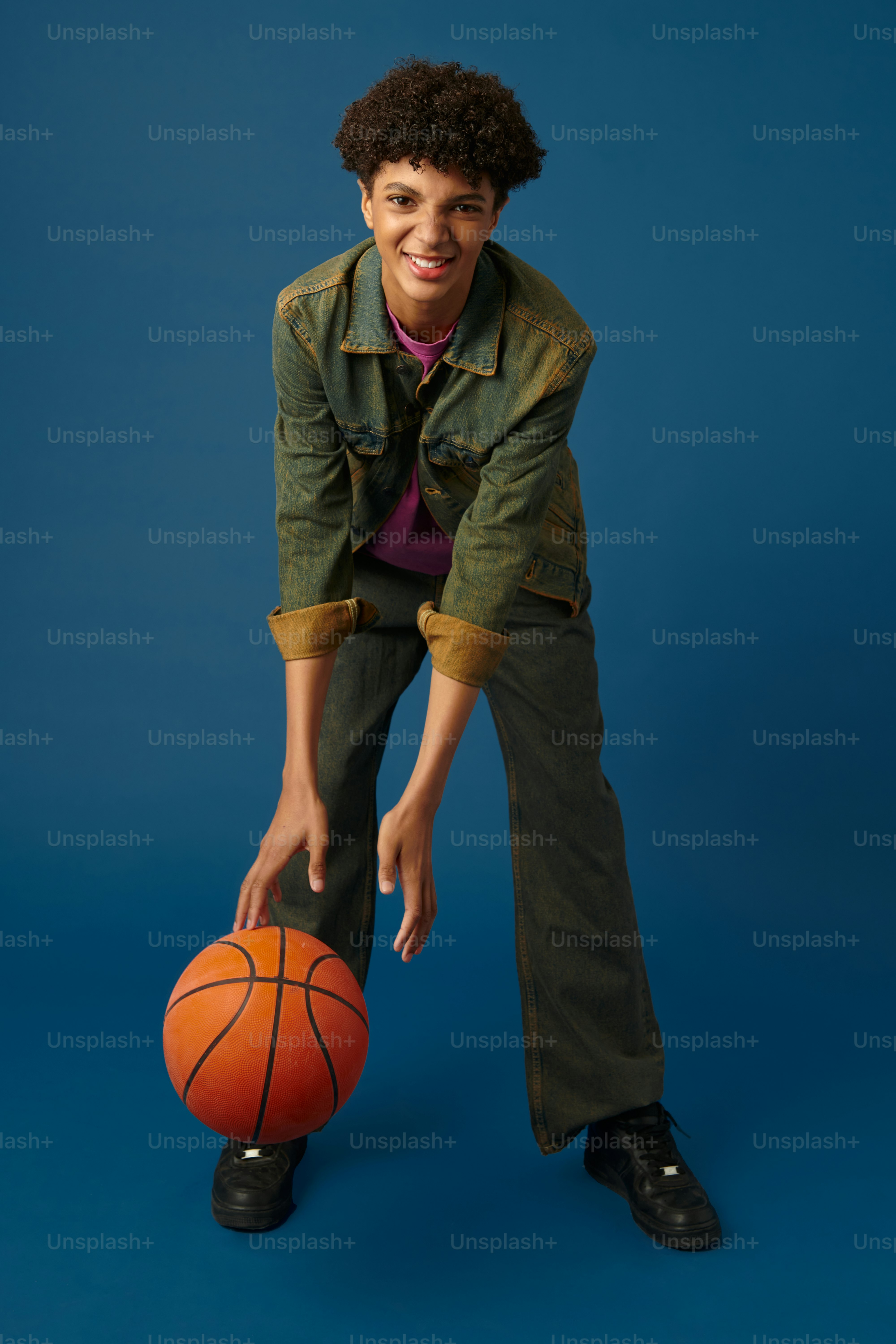 A tween holding a basketball on a blue background photo – Basketball ...